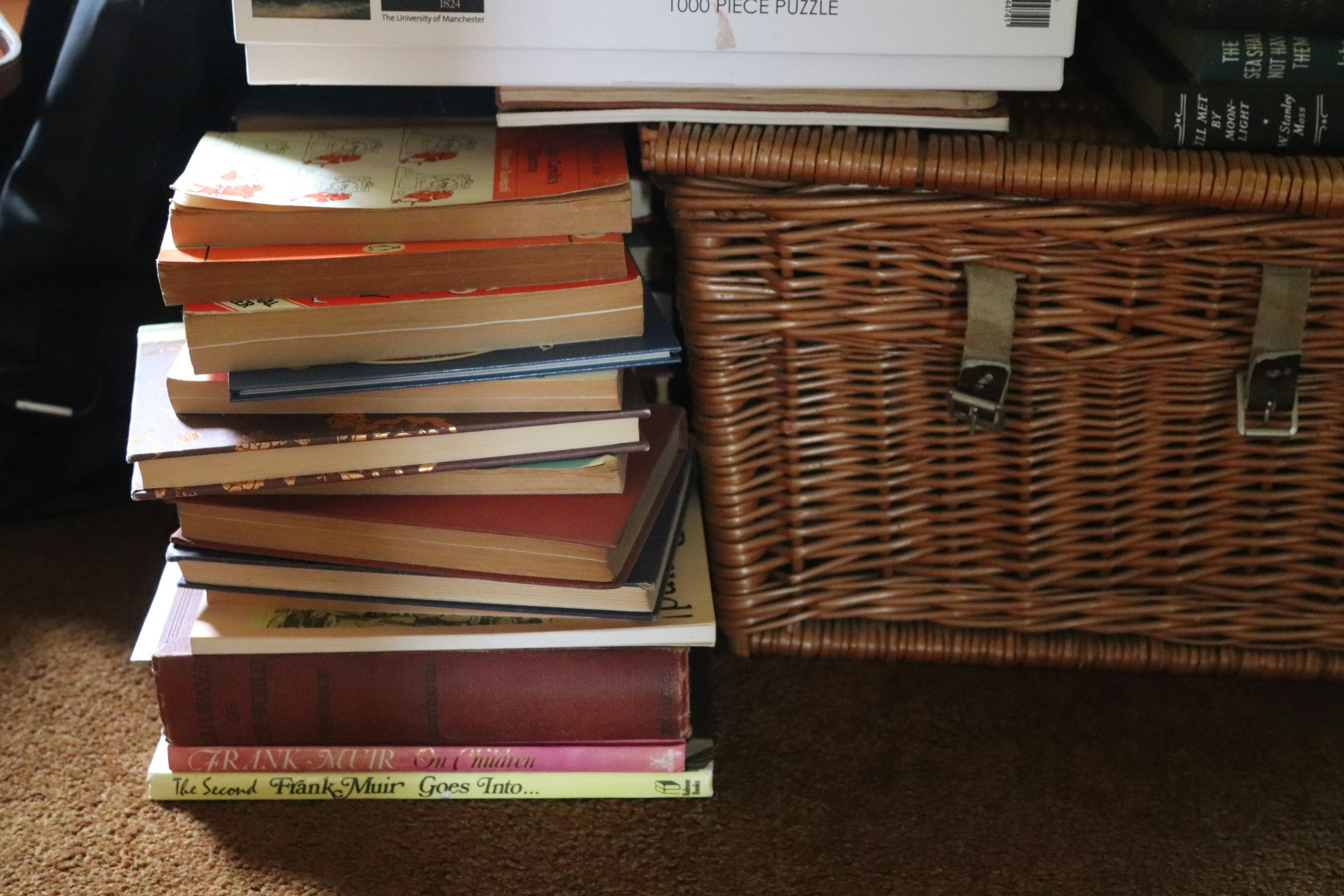 A stack of old books beside a woven trunk. photo – Free Book Image on ...