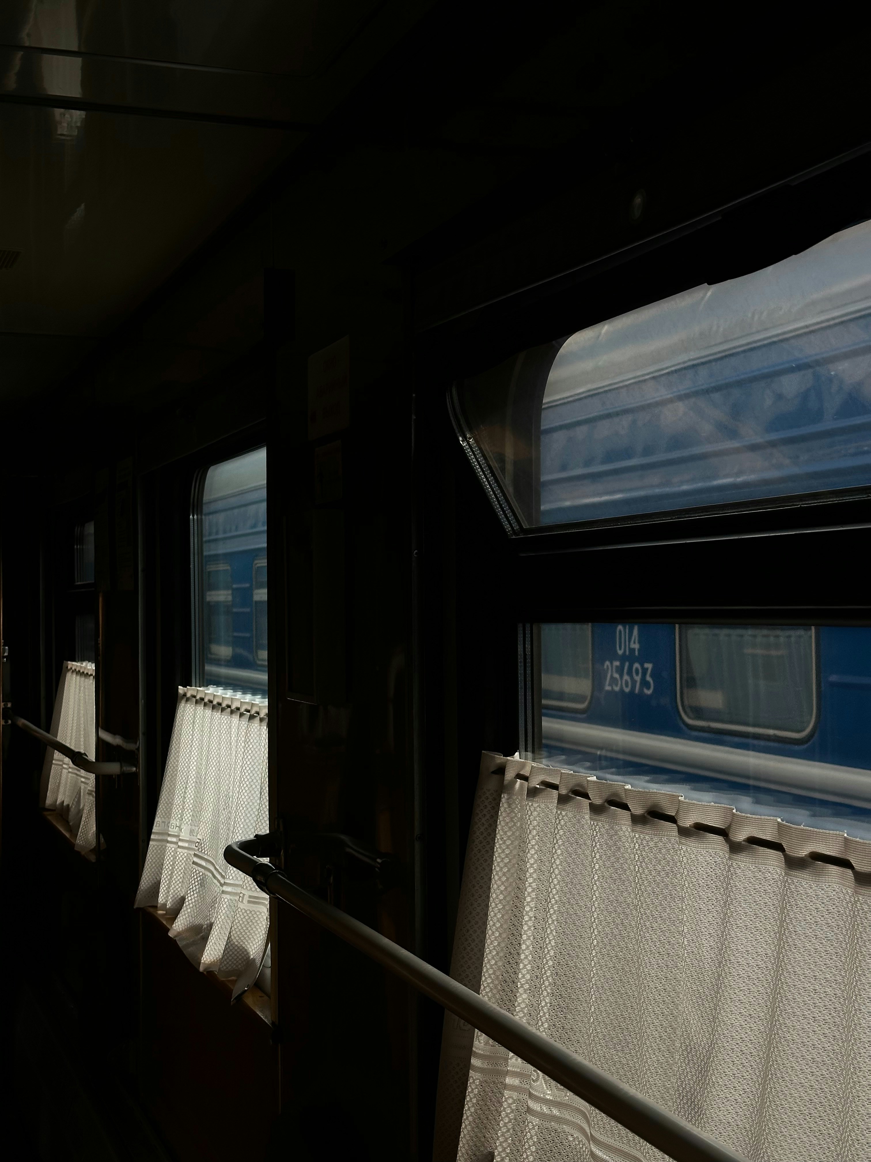 Inside of a dark train car with curtains.