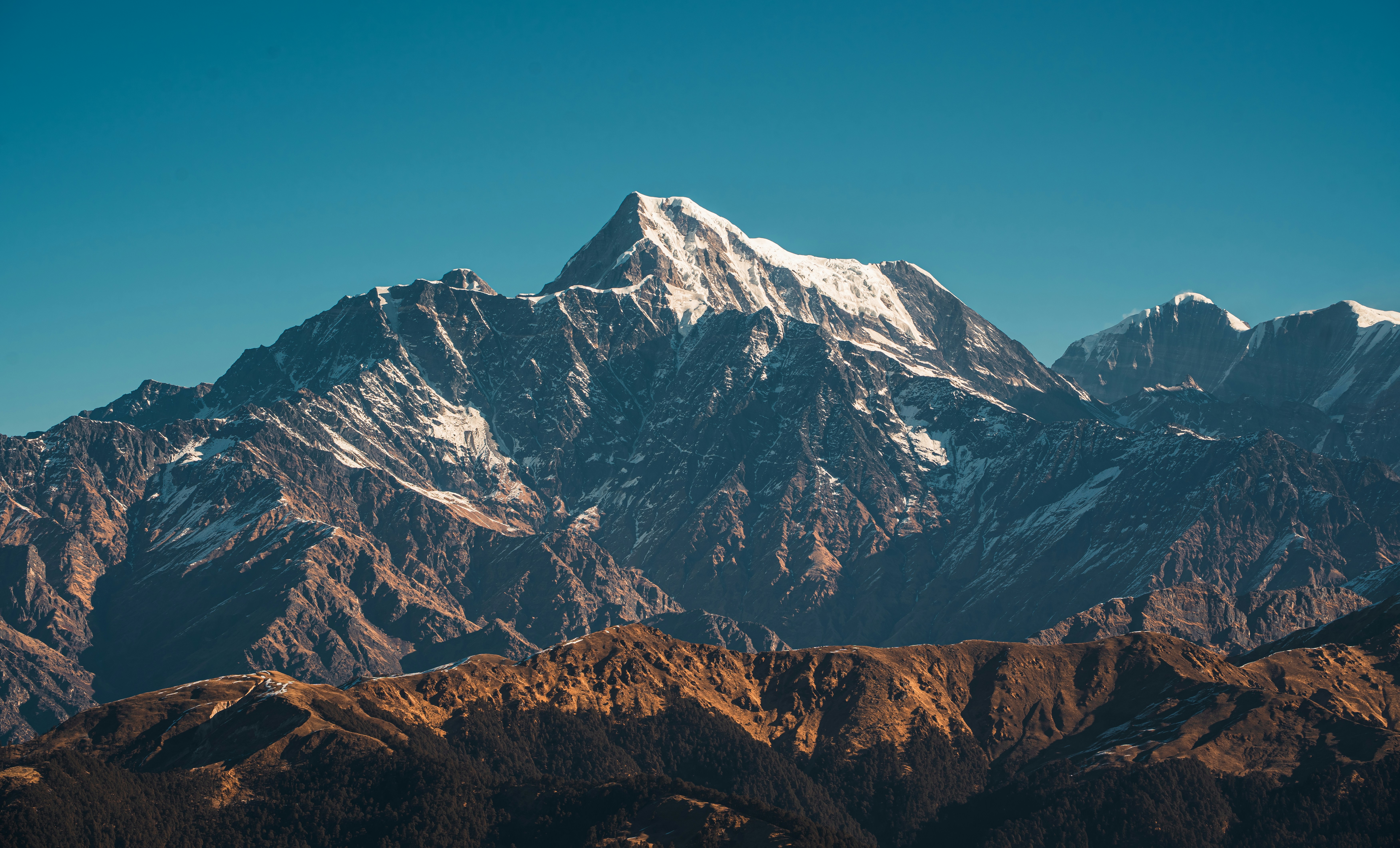 Snow-capped mountains rise against a clear blue sky.