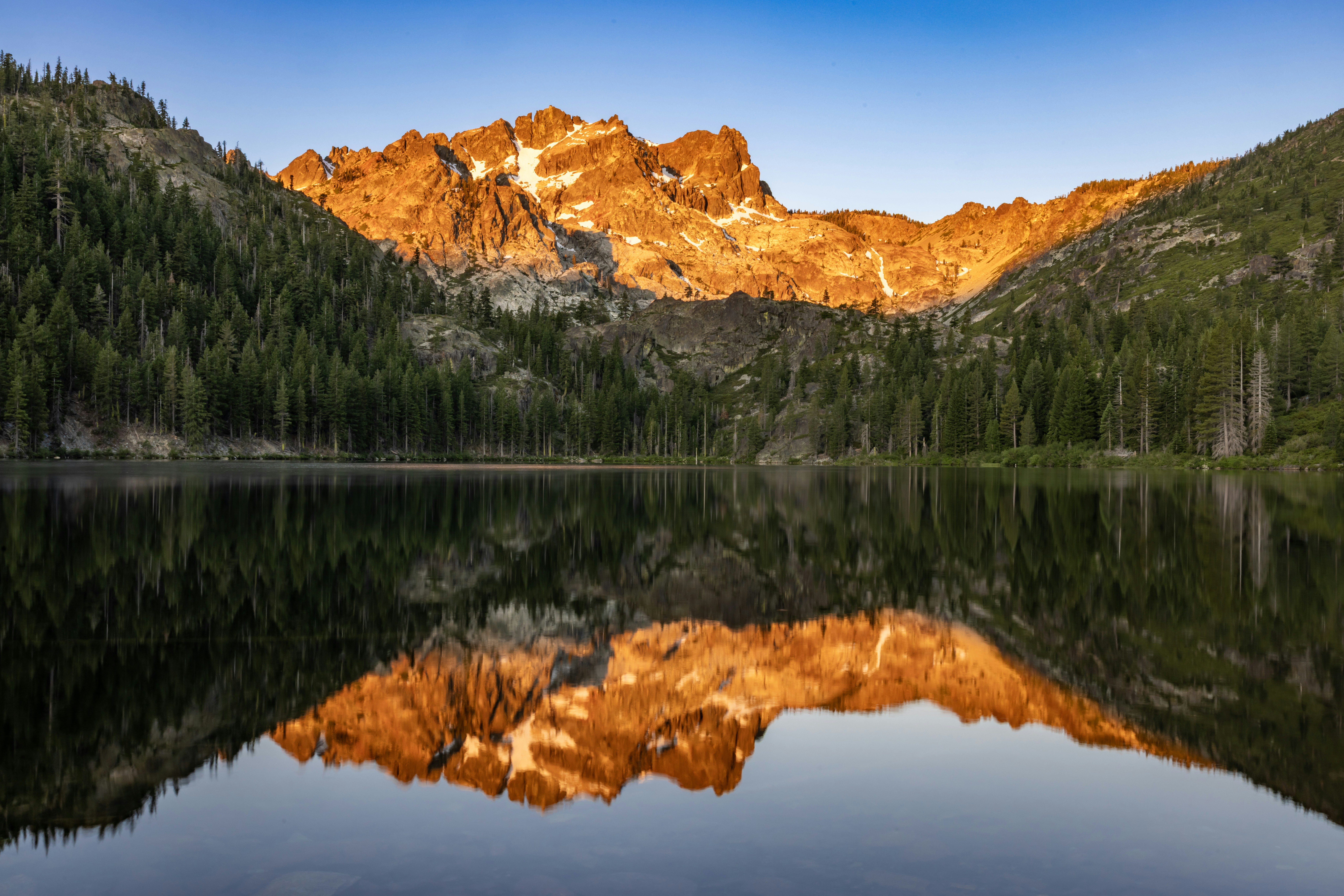 Sunrise on the Sierra Buttes. One of the most magnificent views I've ever seen. | Mountain is reflected in the beautiful lake water.