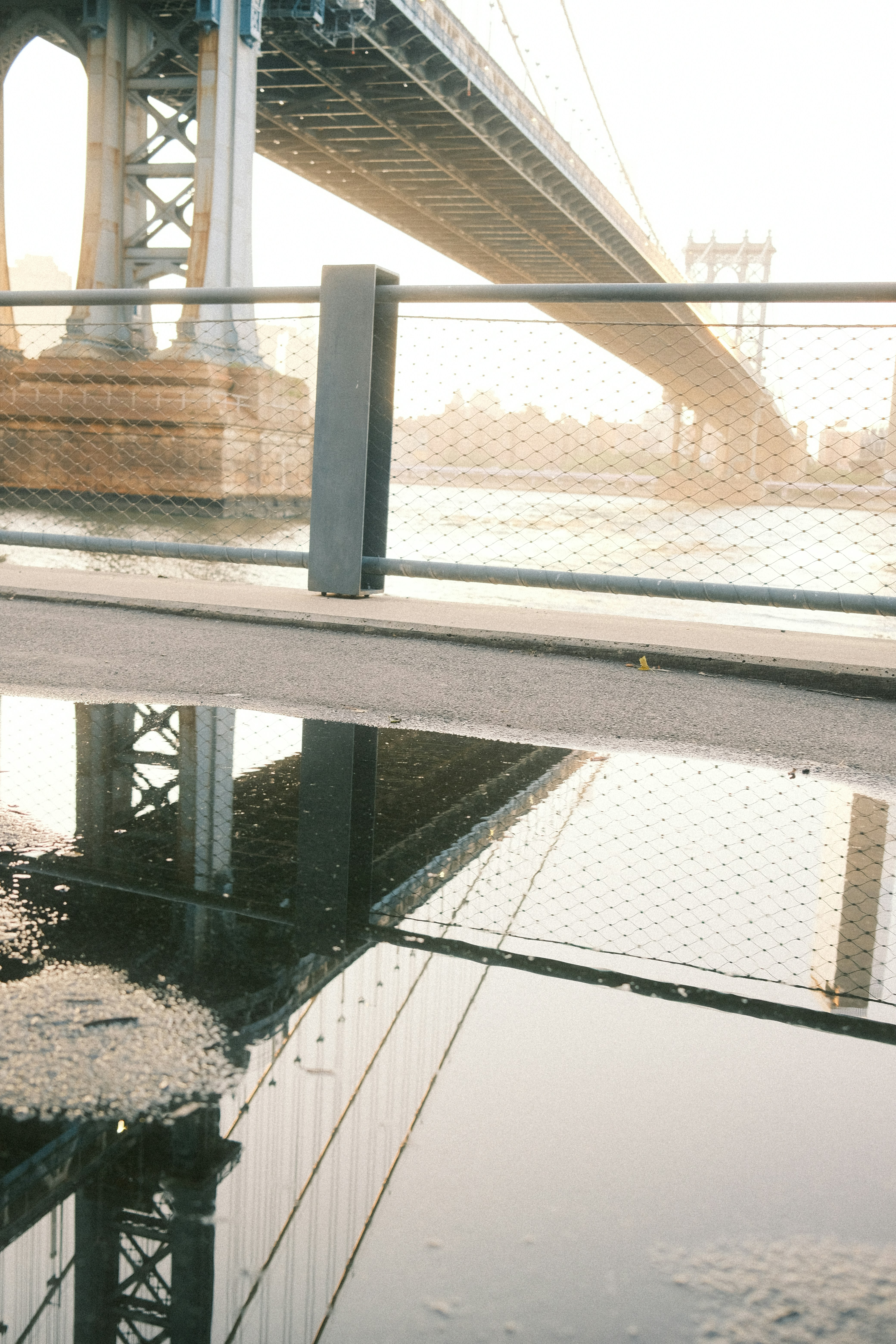 A bridge reflects in a puddle of water. photo – Free City Image on Unsplash
