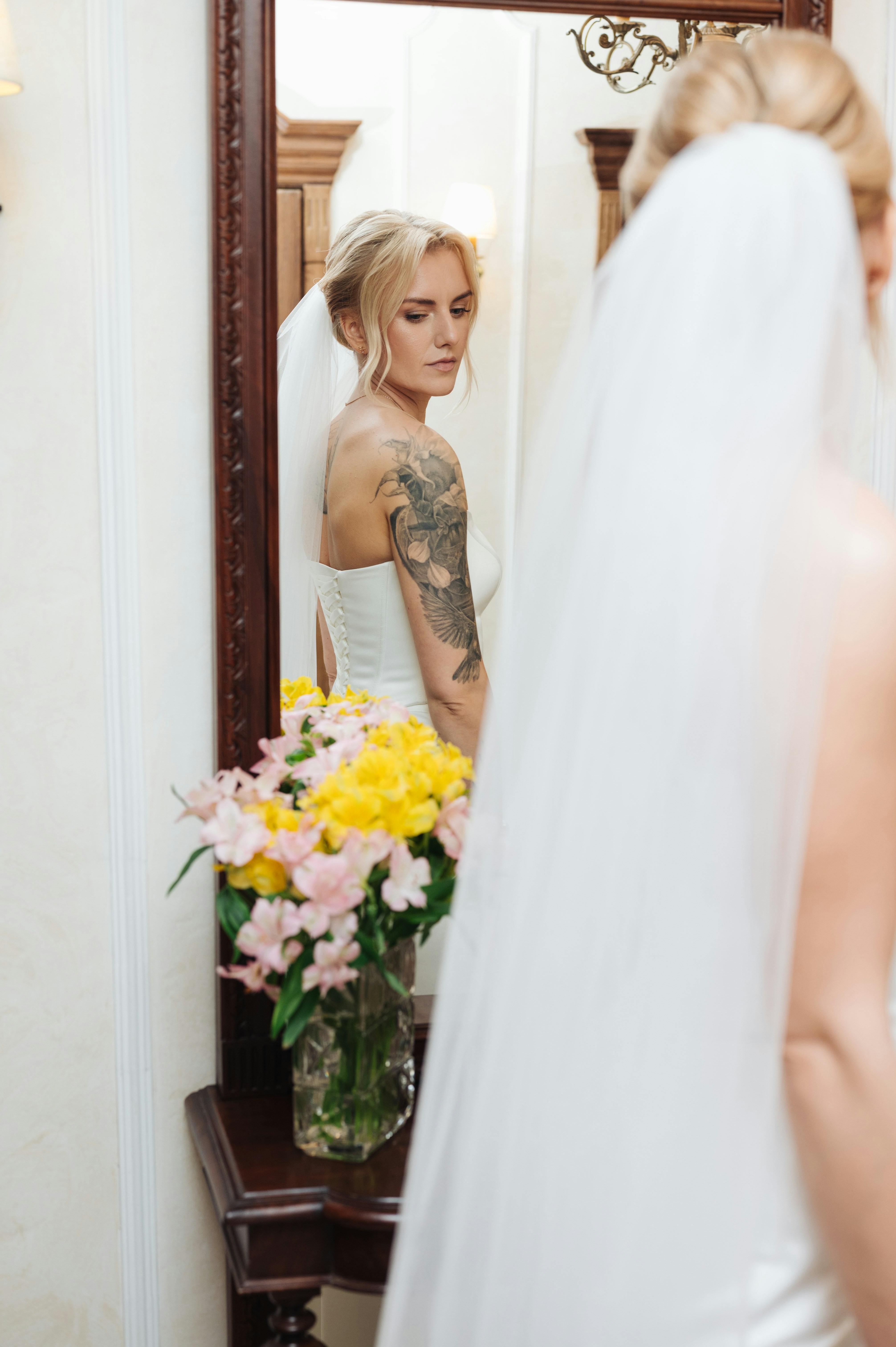 A bride gazes at her reflection in the mirror. photo – Free Flower ...