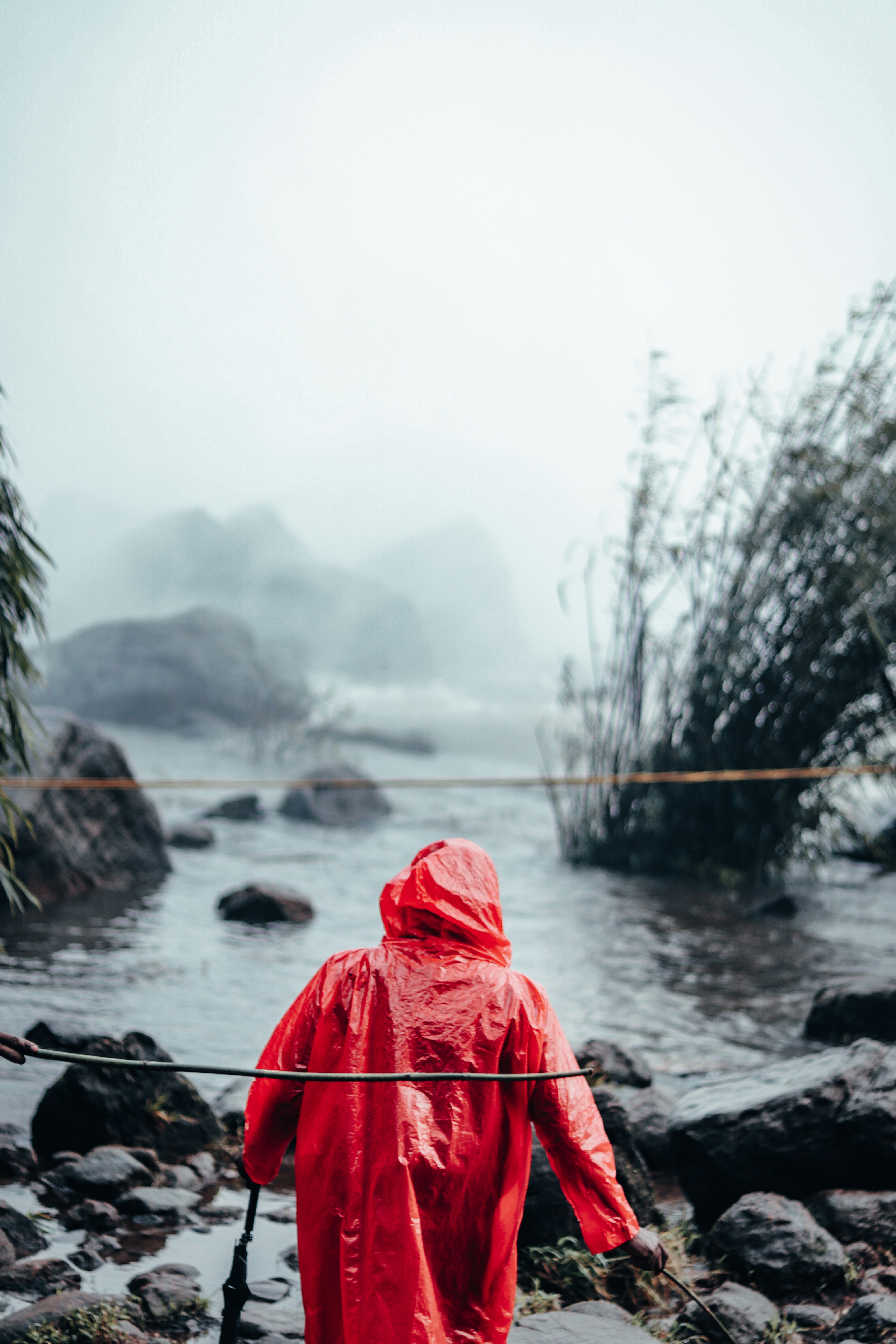 Red Cloaked Figure Confronts a Misty Coastal Shore