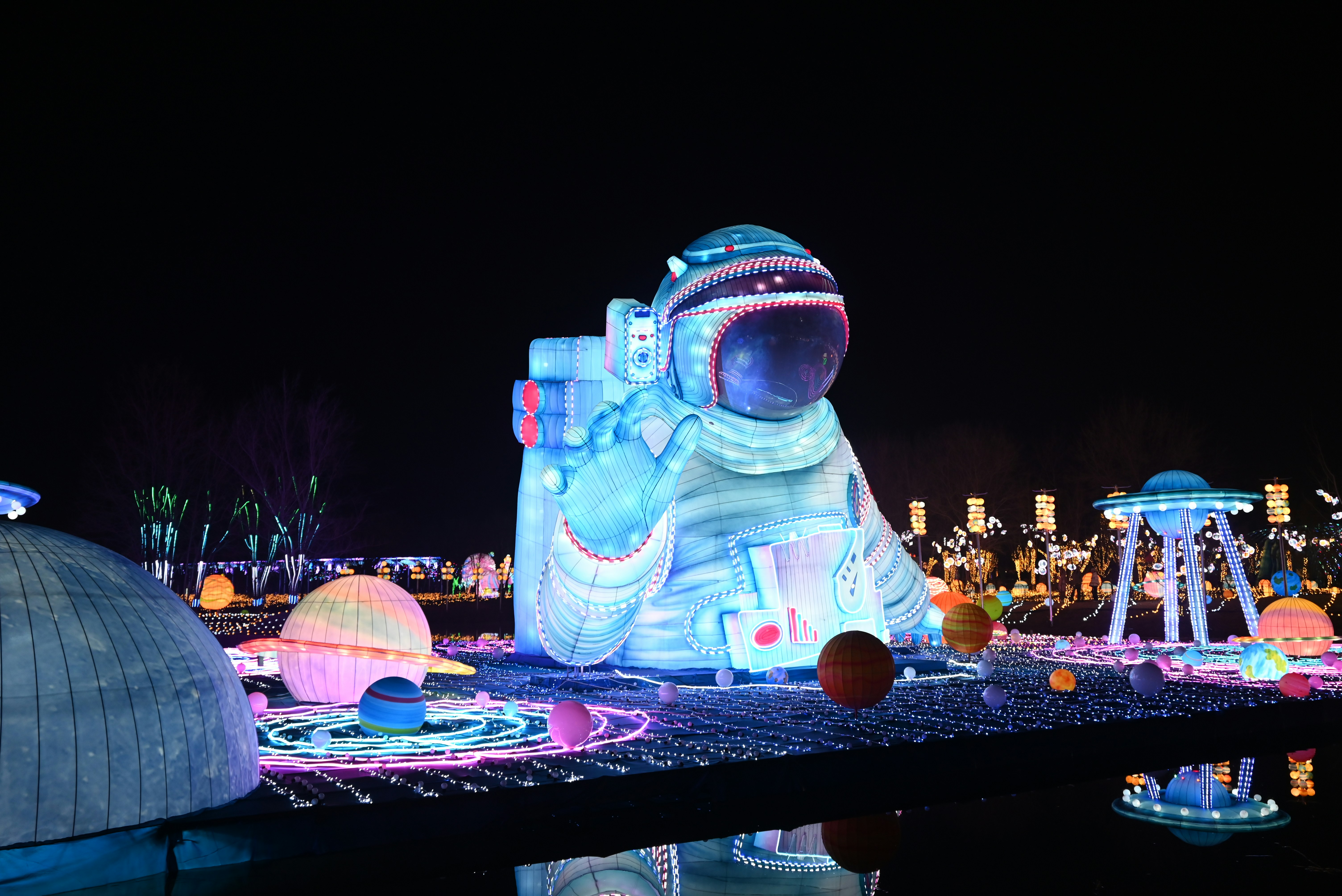 Neon Colossus by the Water: Blue Titan Among Floating Orbs