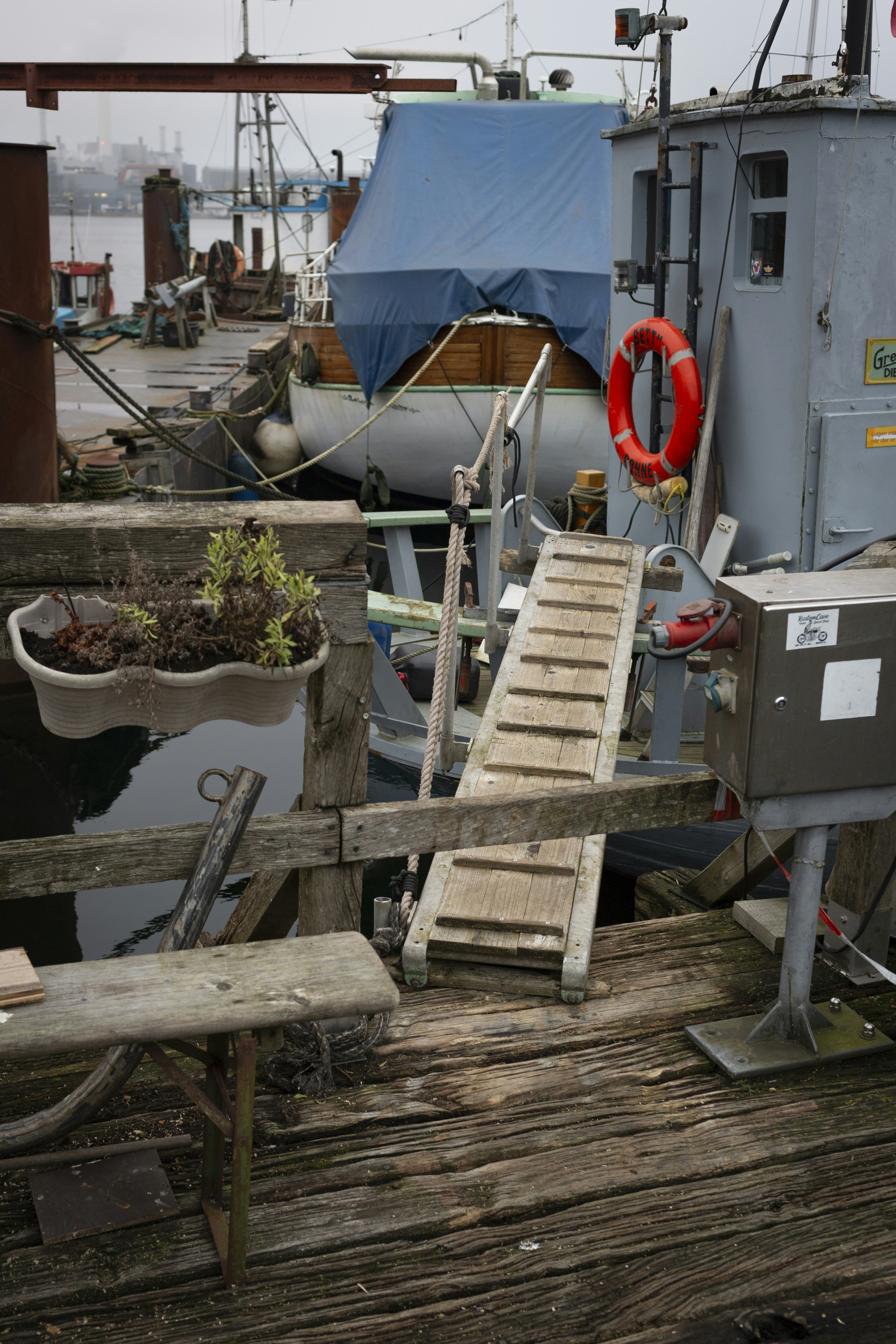 Boats are docked at a weathered wooden pier.