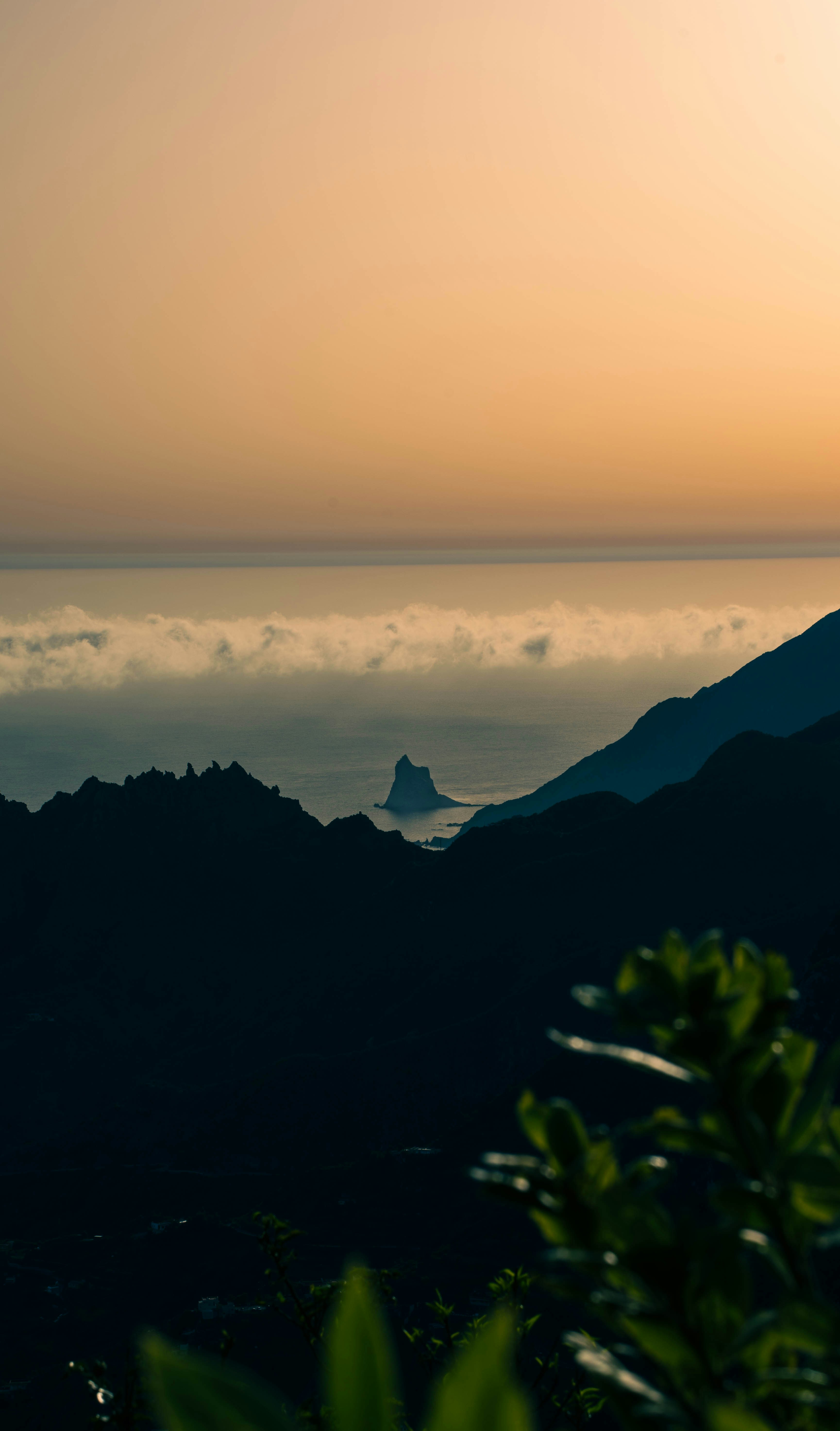 Dramatic sunset over mountain range and ocean.