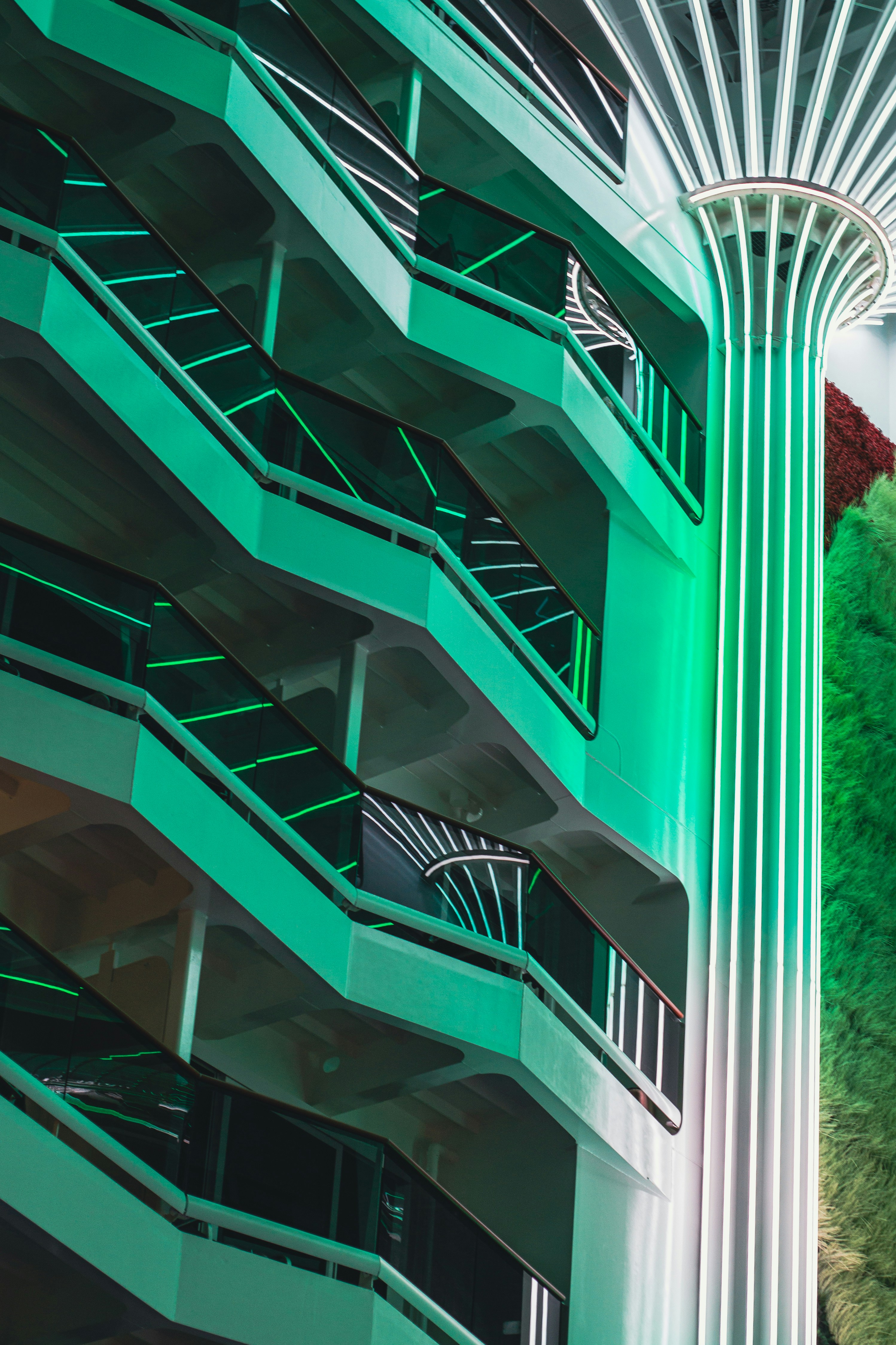 Emerald Facade: Parallel Staircases and a Neon Ribbed Column