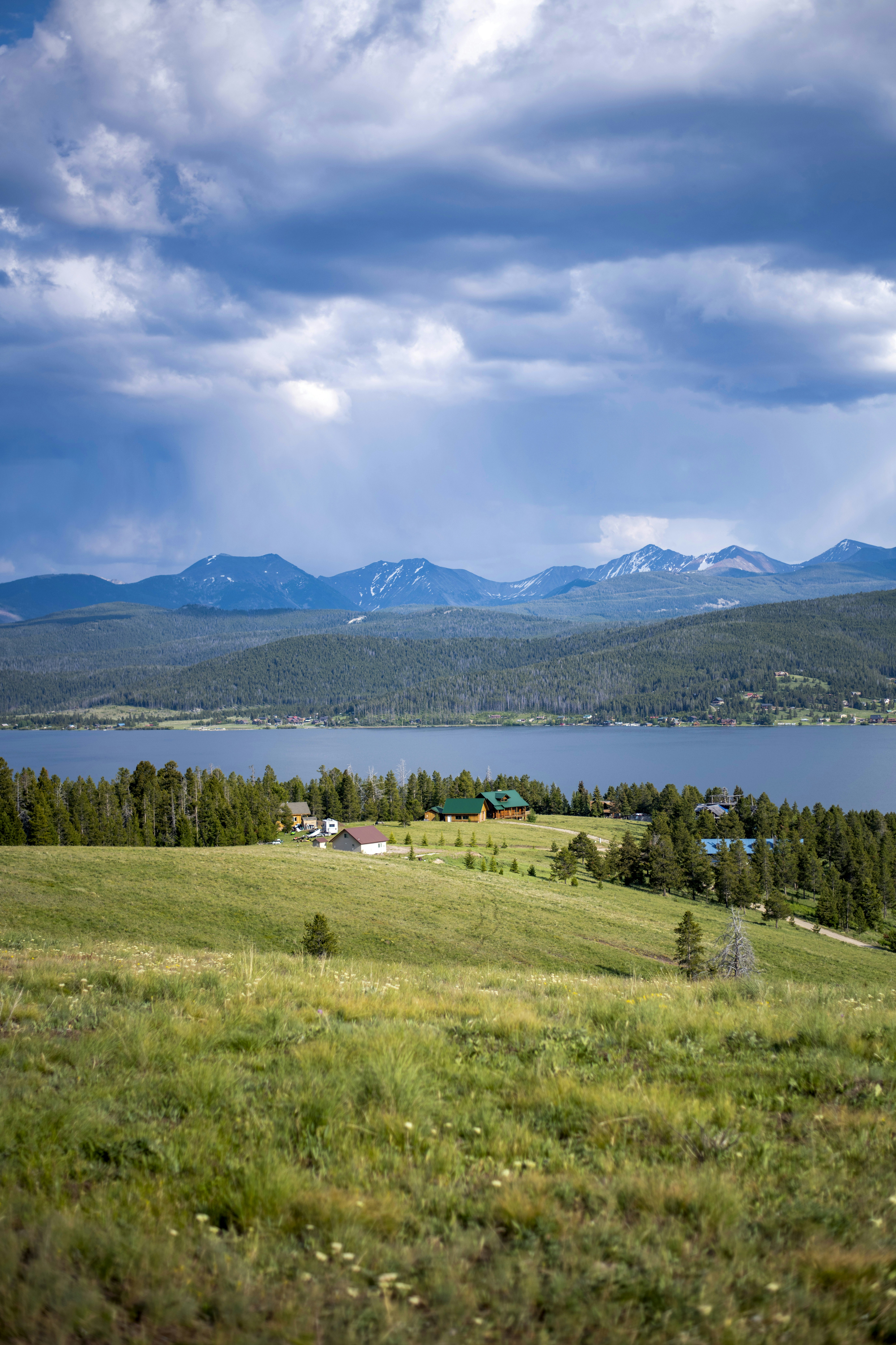 Rolling hills lead to a lake and mountains.