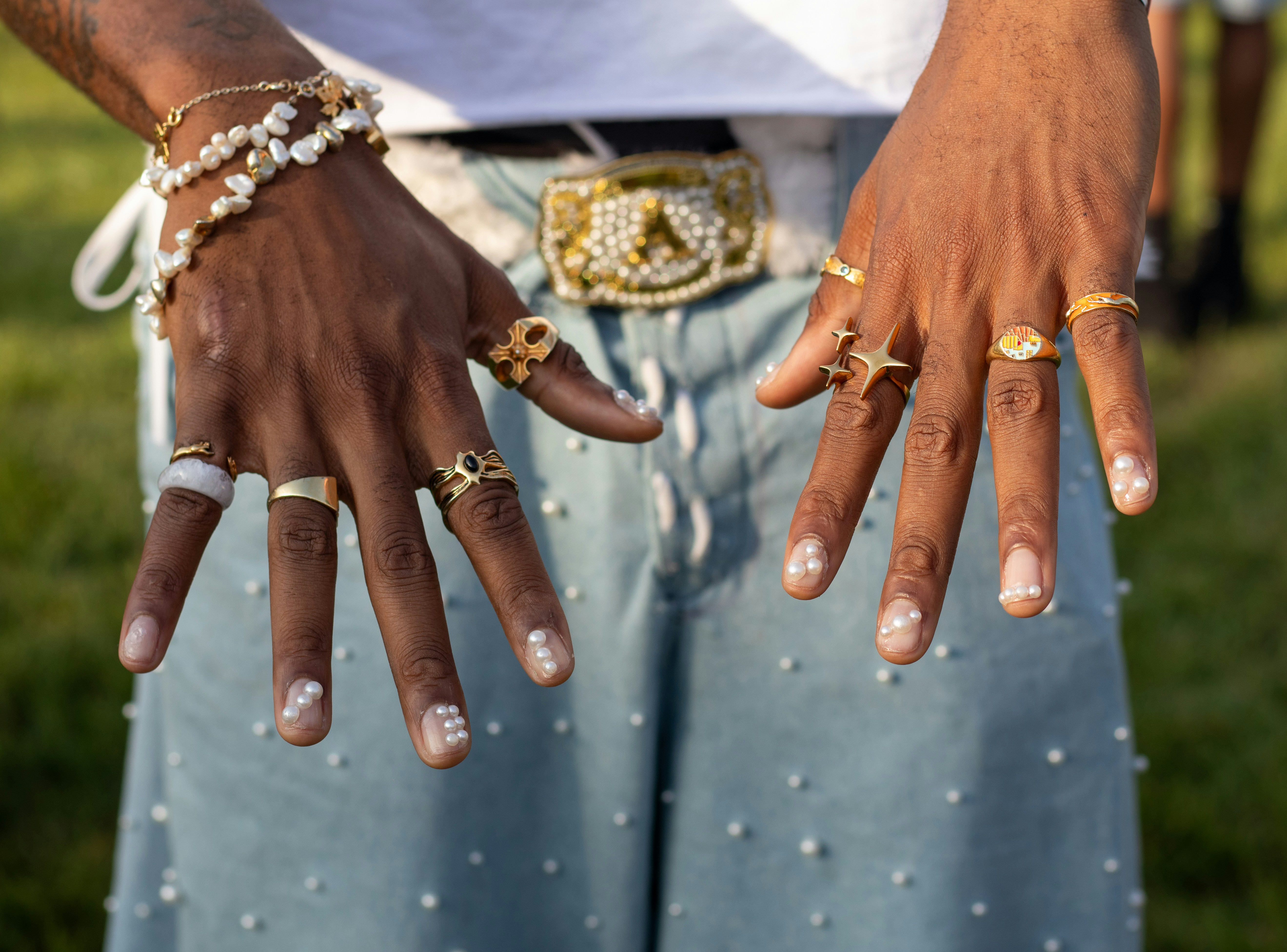 ' | Hands showcase jewelry and patterned nails.