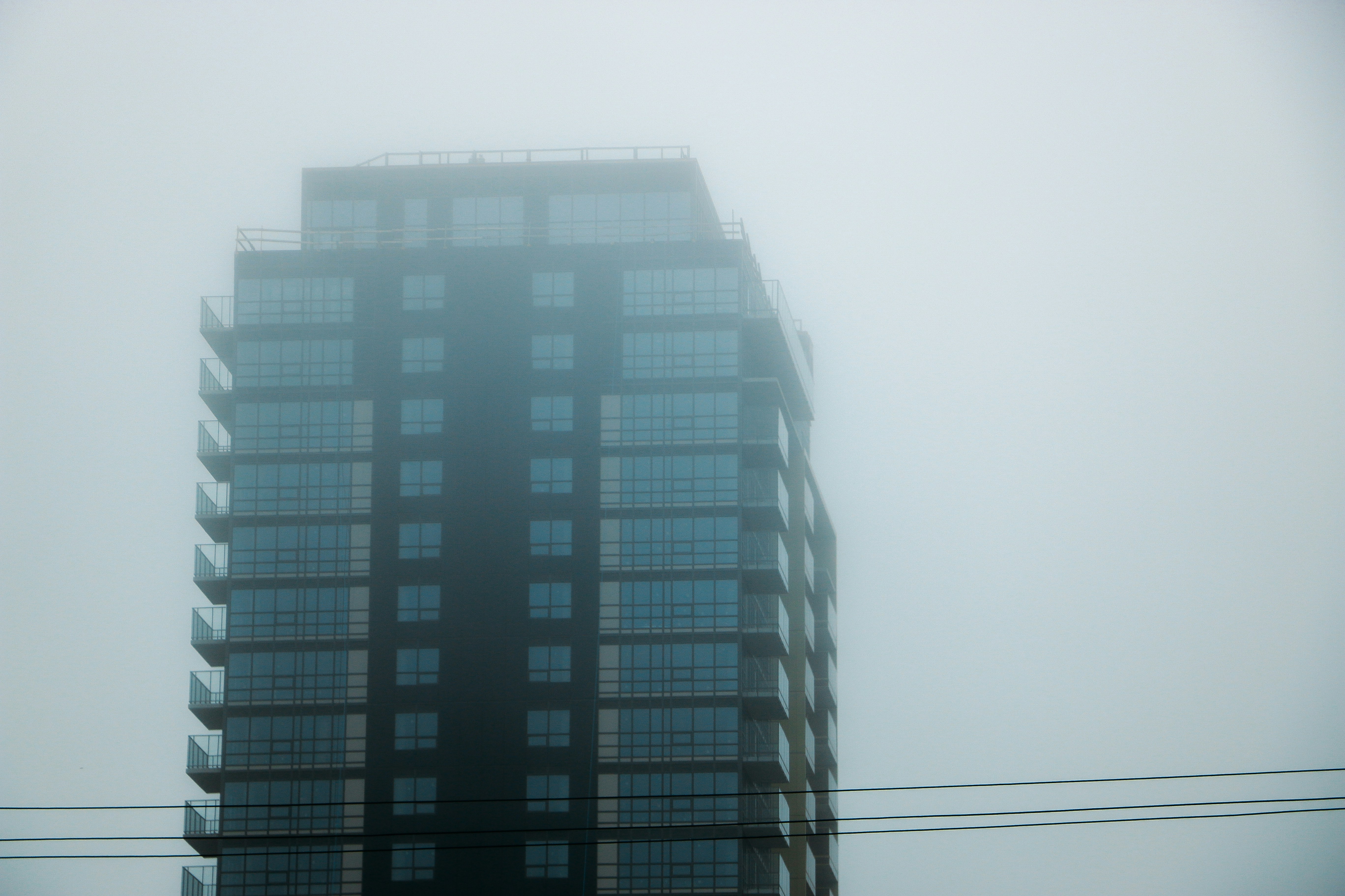 A tall building is shrouded in thick fog.
