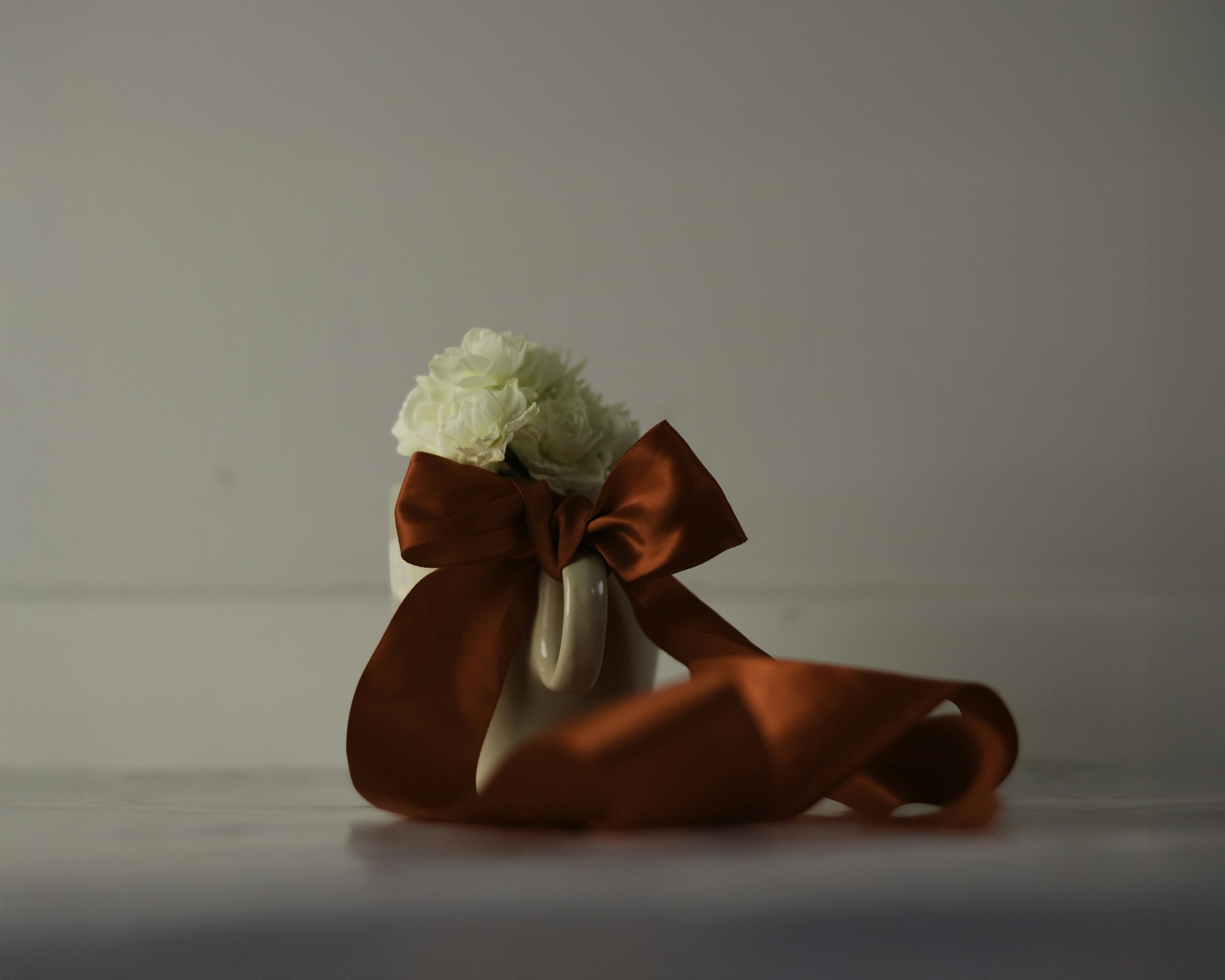 red ribbon on cup | A gift bag is decorated with a red bow.