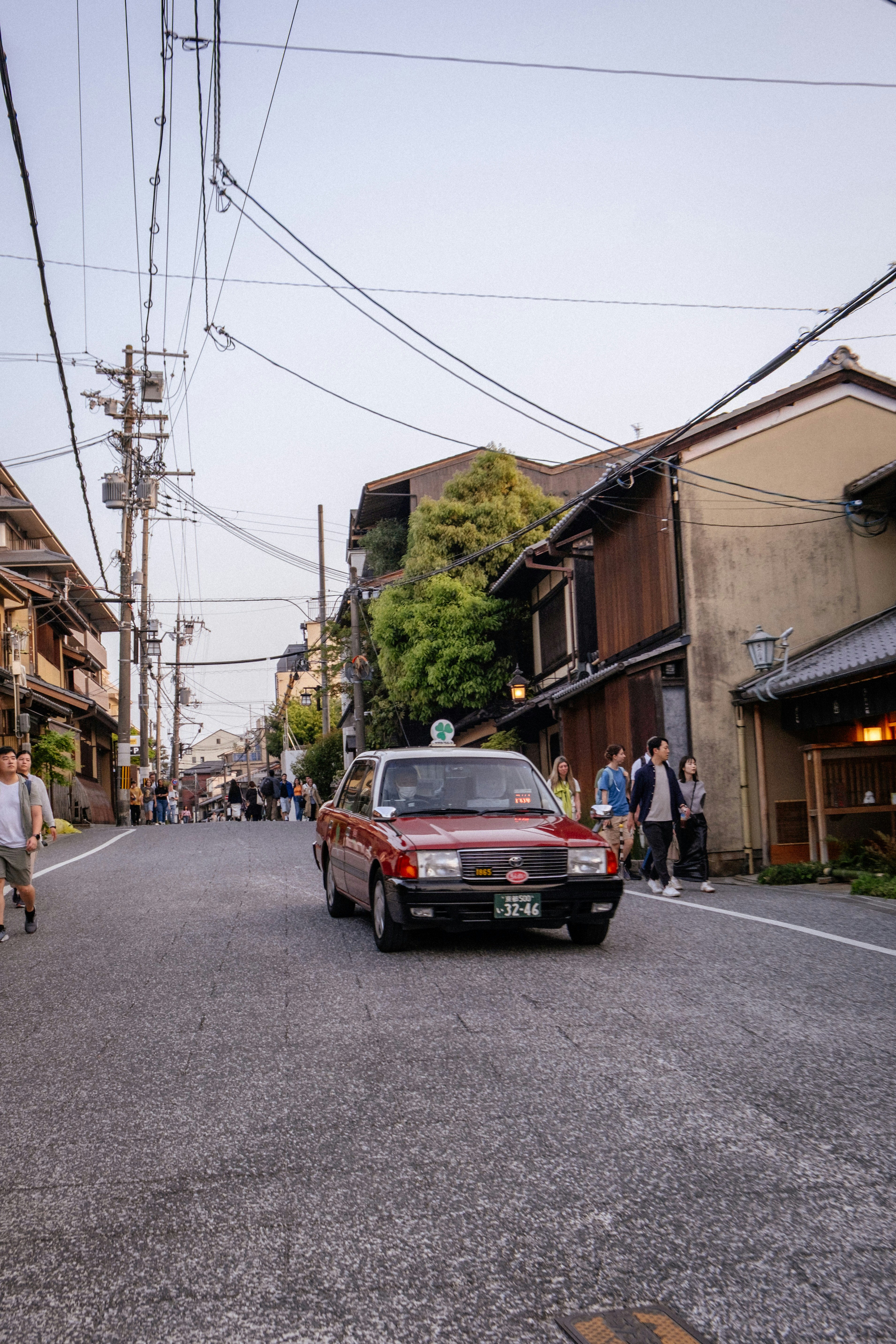 Red Taxi on a Quiet Japanese Street as Evening Light Falls