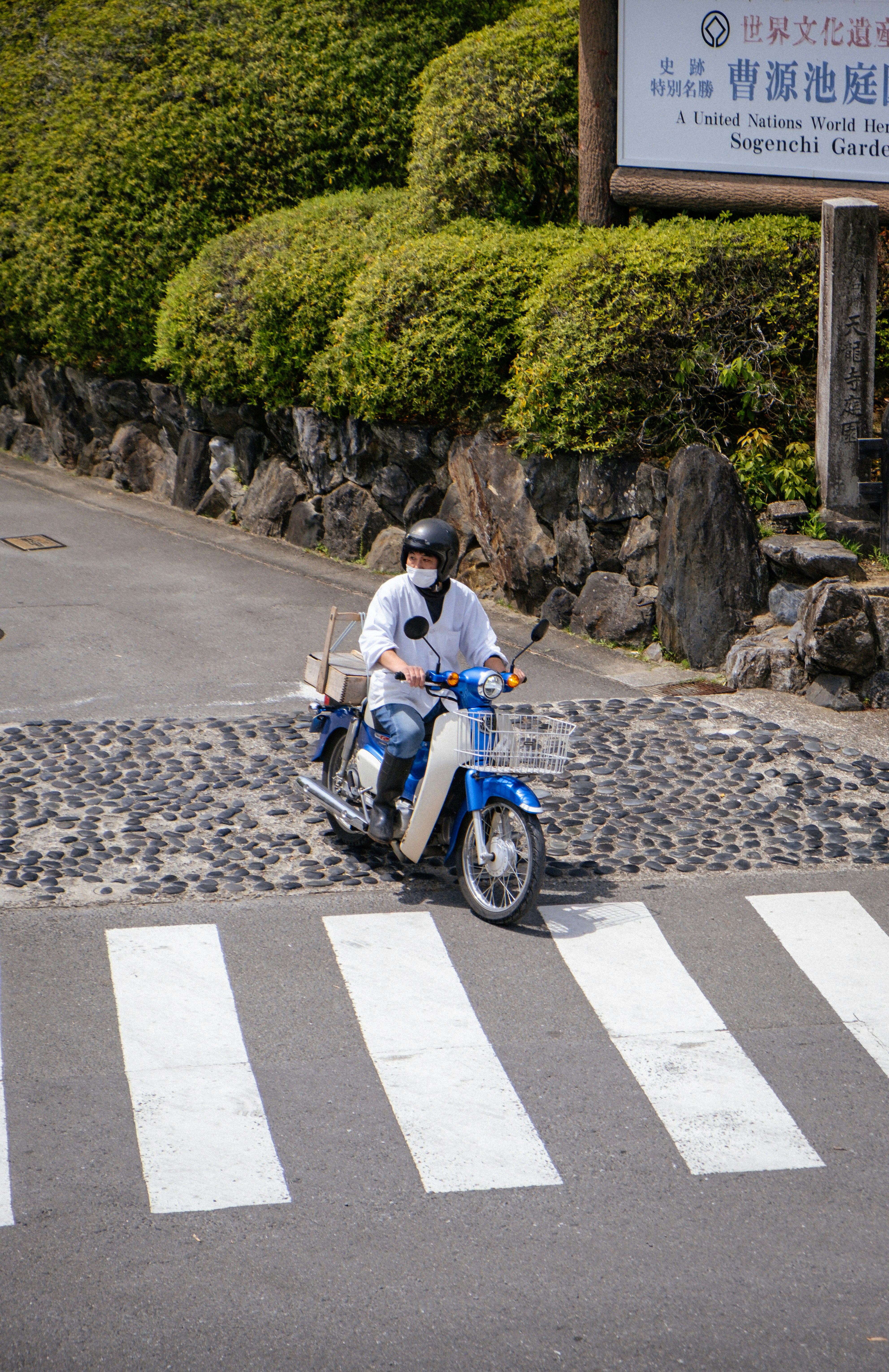 A person on a scooter crosses a crosswalk.