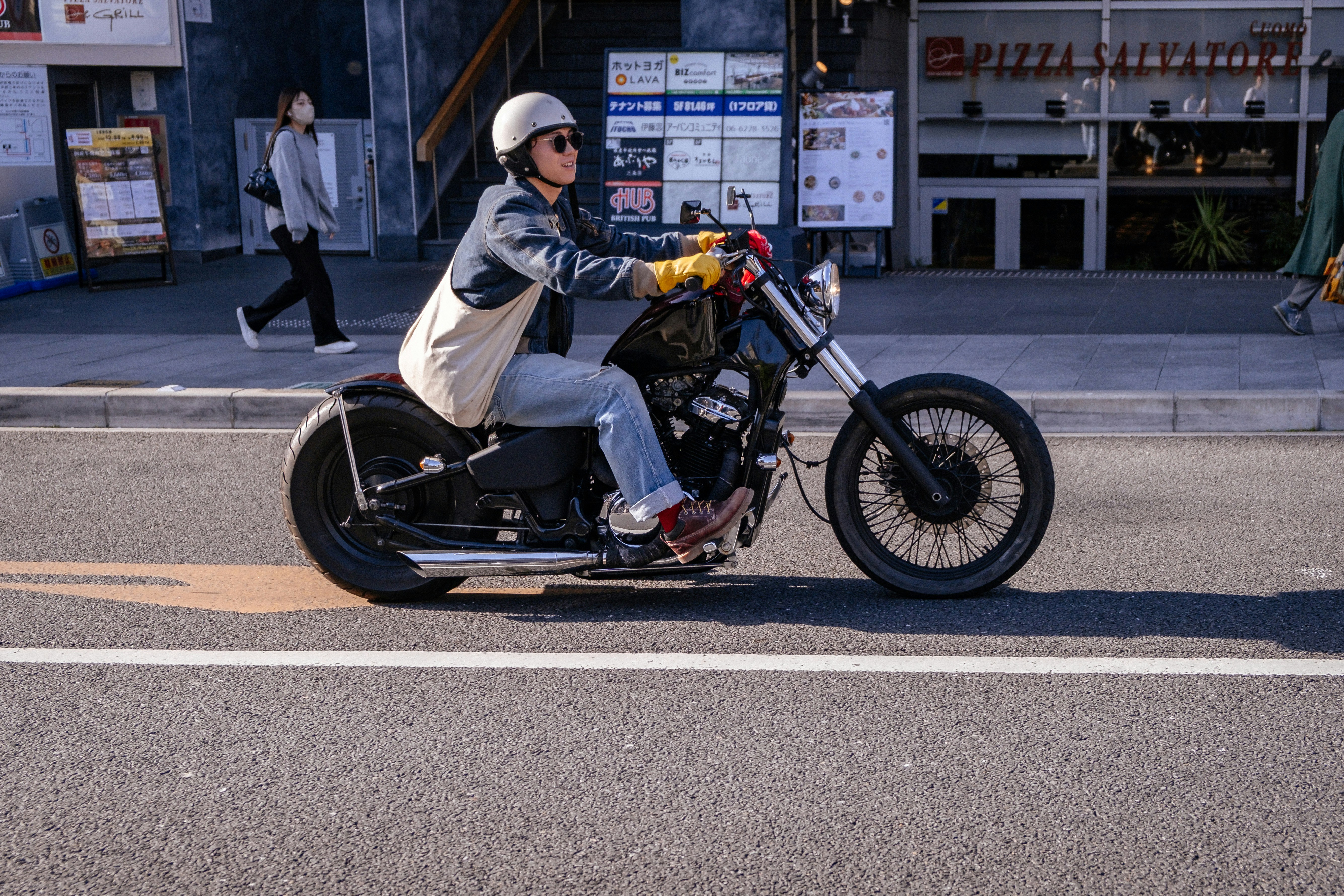 A person rides a motorcycle down a city street.