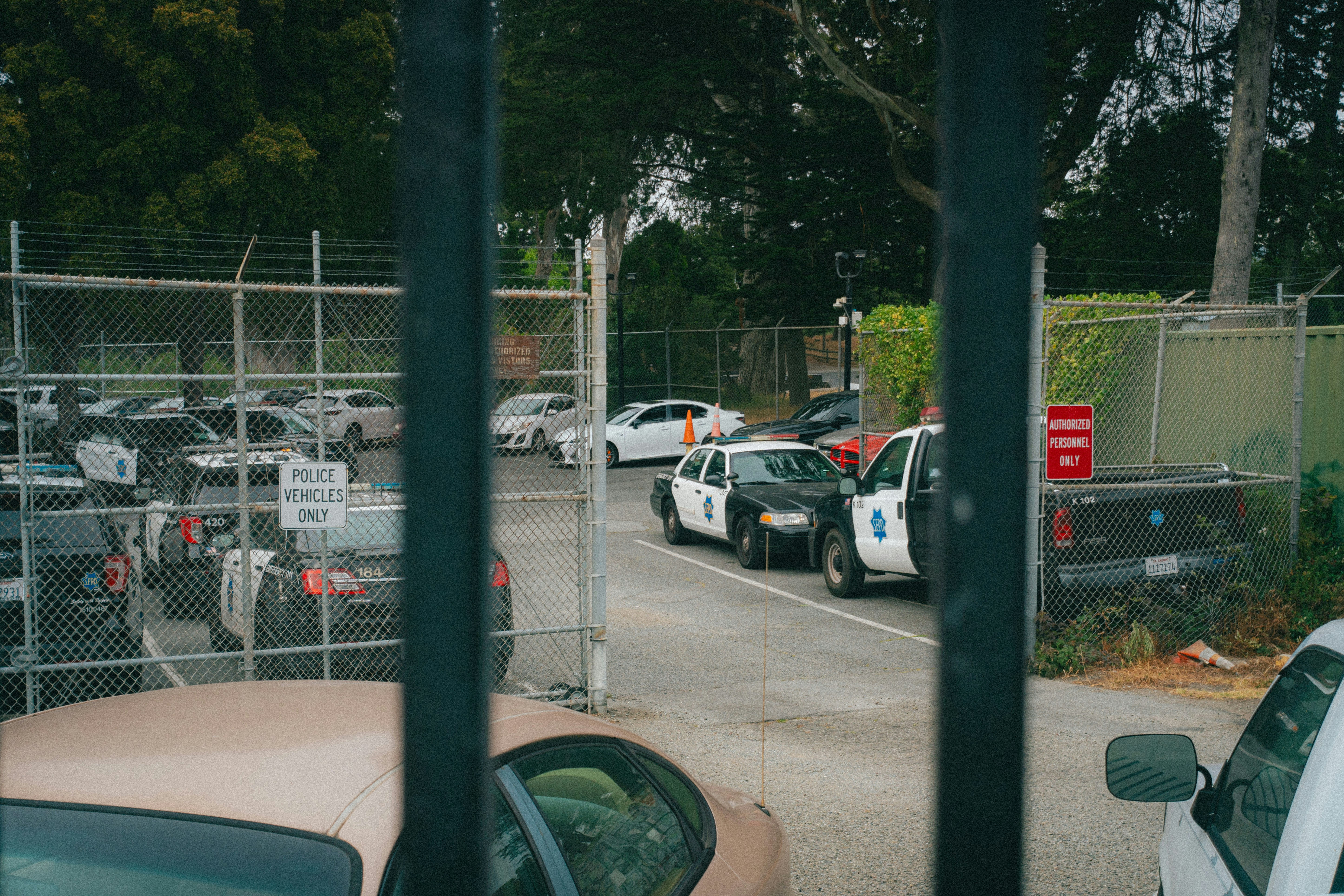 Police cars are parked inside a fenced parking lot. photo – Free Usa ...