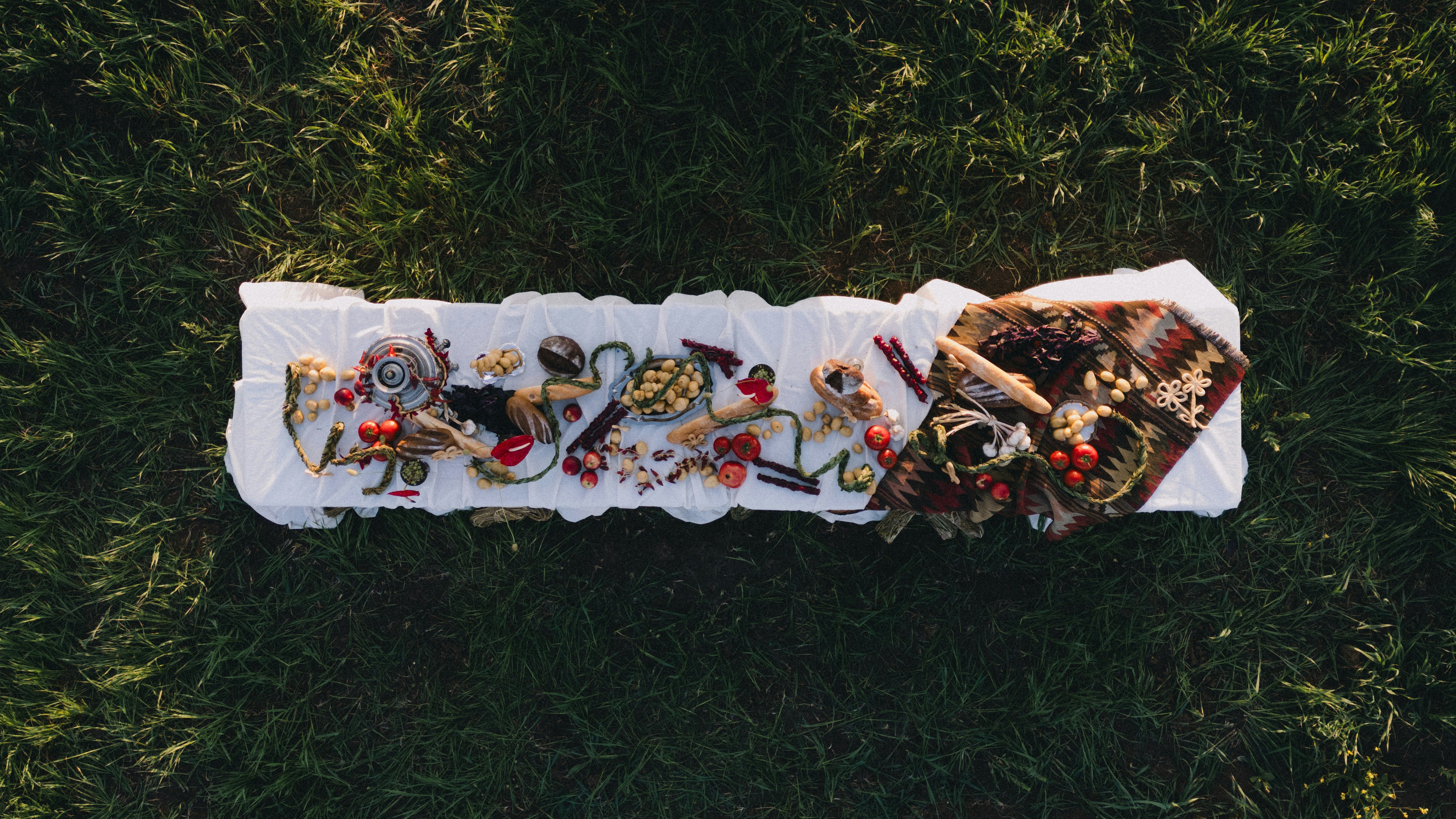 A table is set with food on the grass.