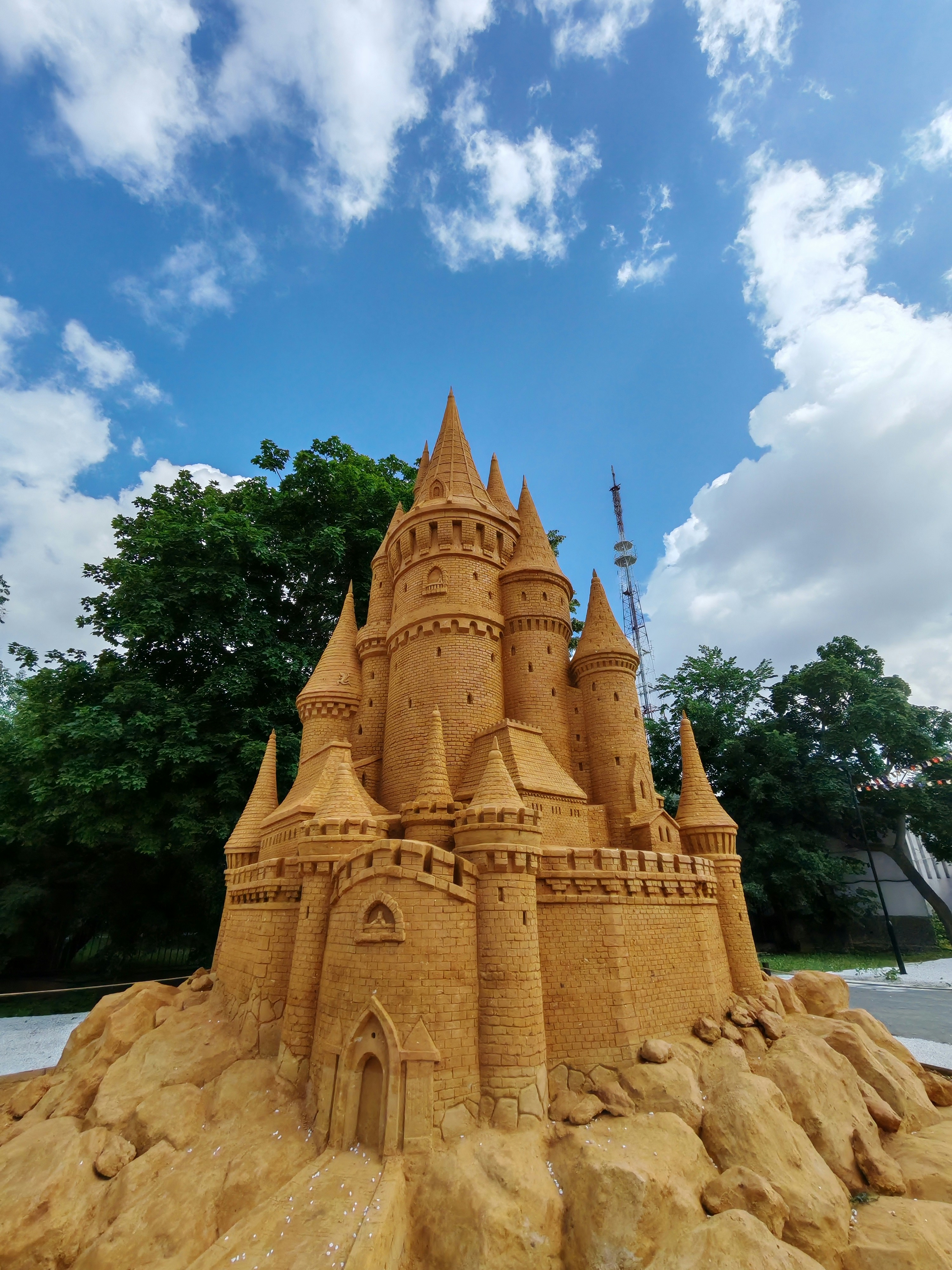 Castle made of sand | Sandcastle stands proudly against a blue sky.