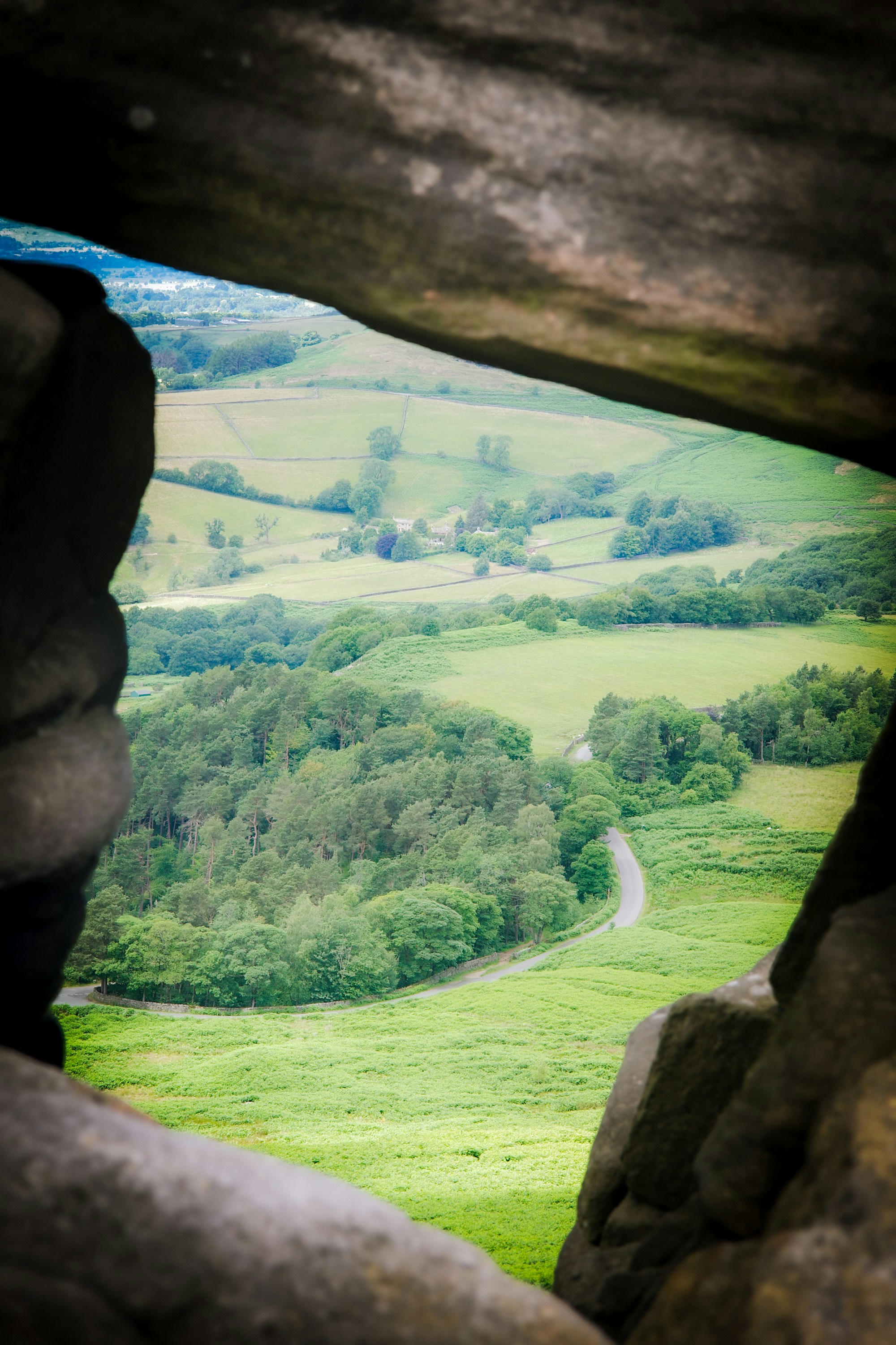 View through a natural window: a rolling countryside framed by ancient rock
