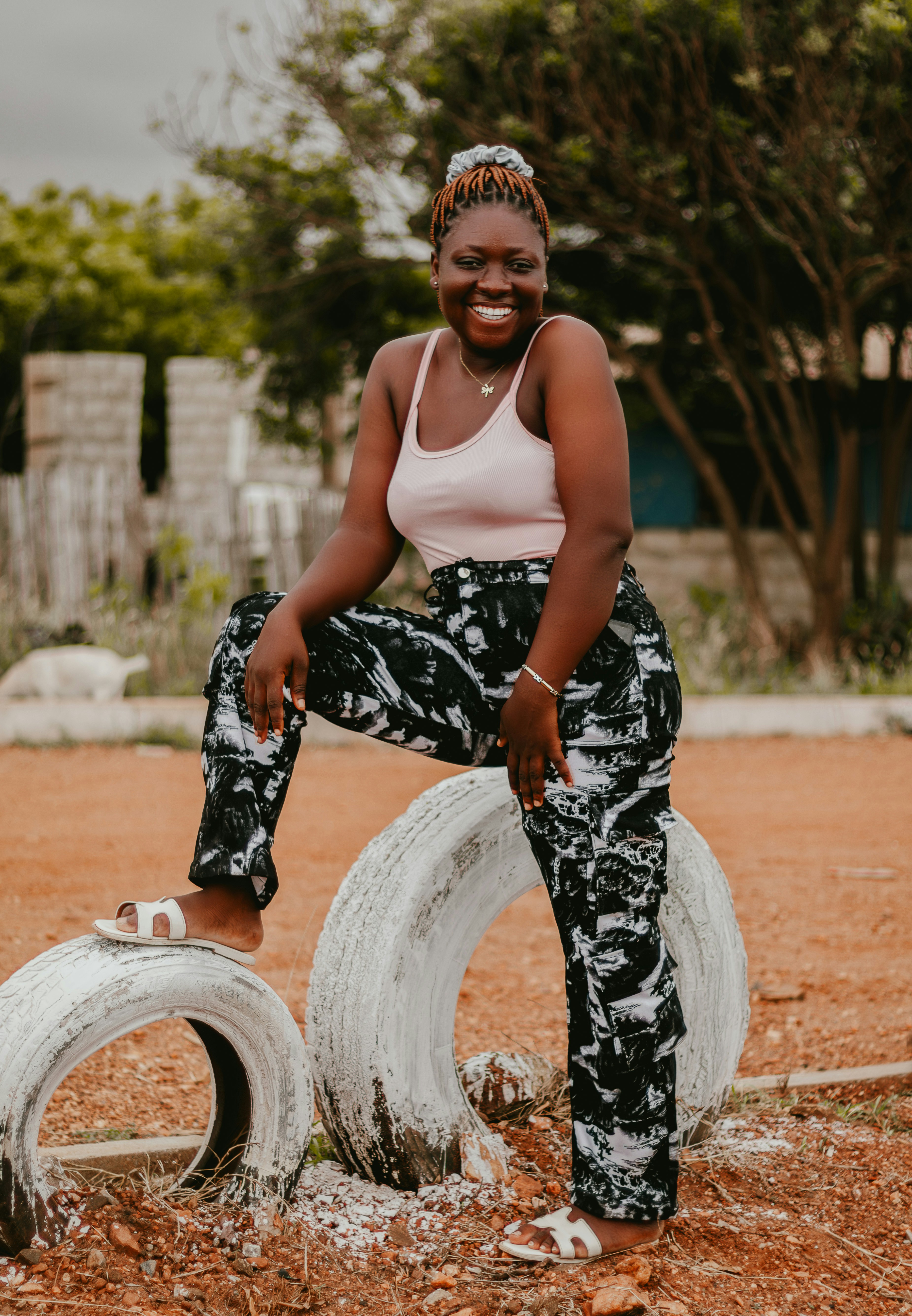 Joy on Reclaimed Tires: A Portrait in a Dusty Yard