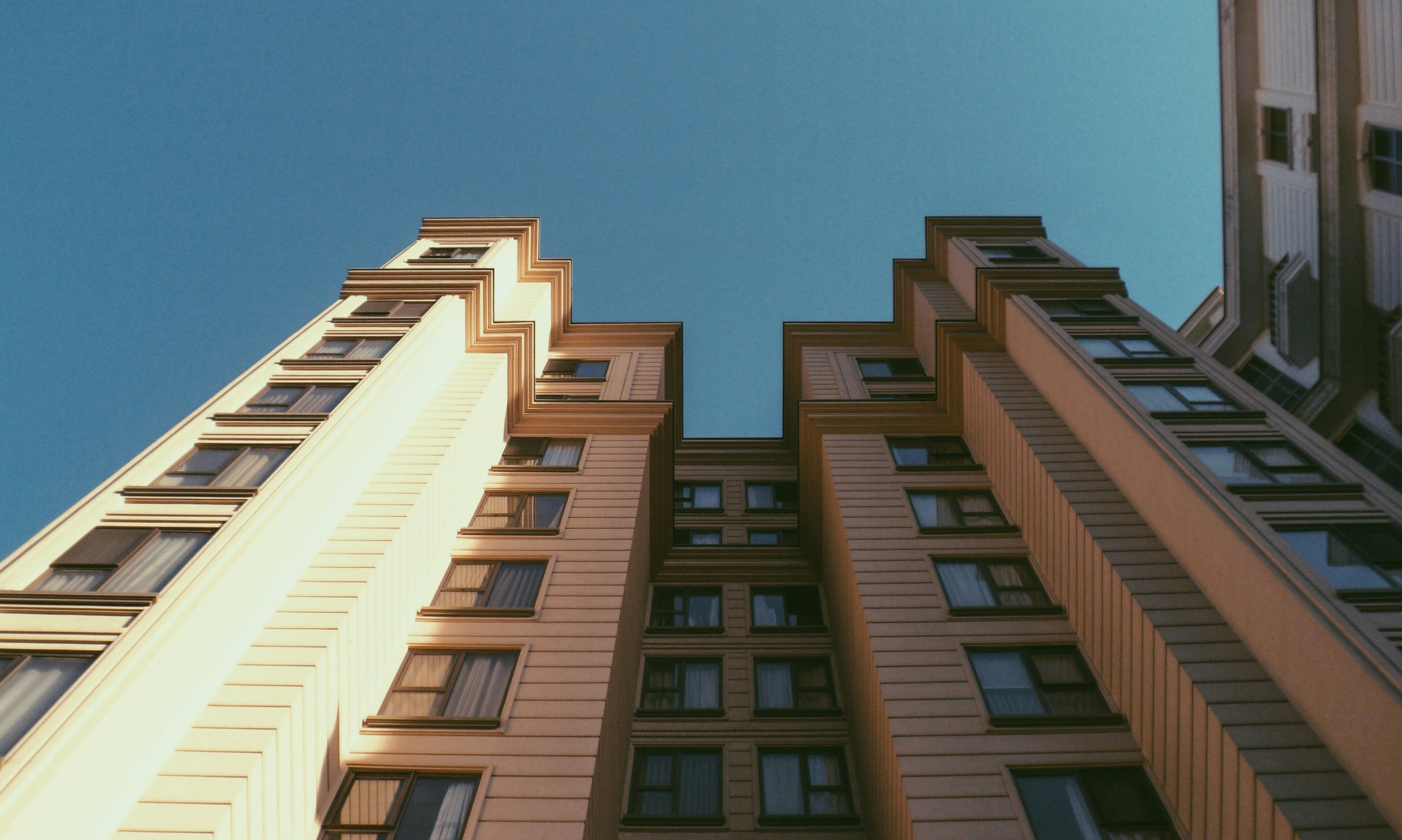 Look up. That's where the sky is. | Looking up at a tall building and blue sky.