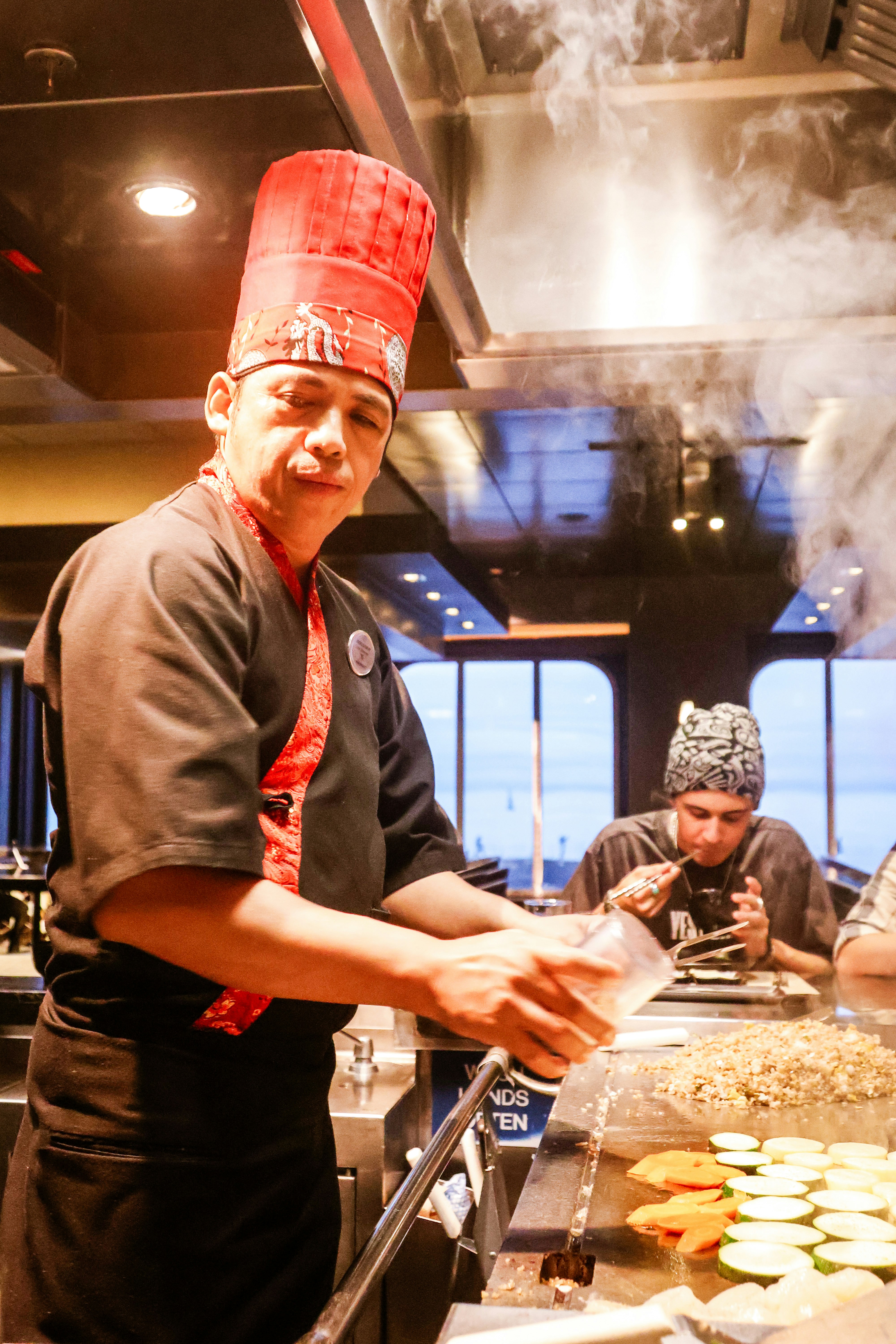 A chef prepares food on a teppanyaki grill.