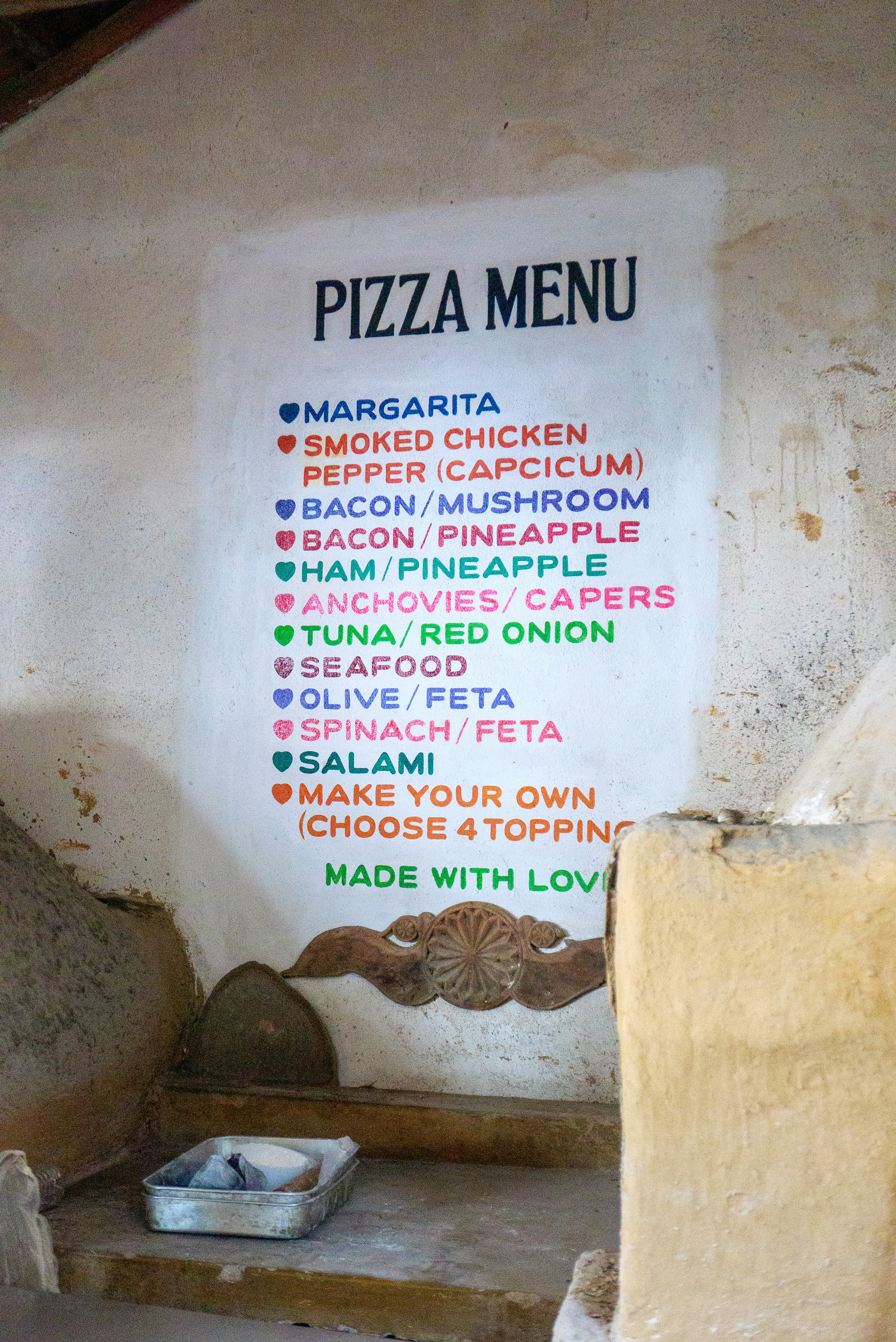 A pizza menu with many topping options.