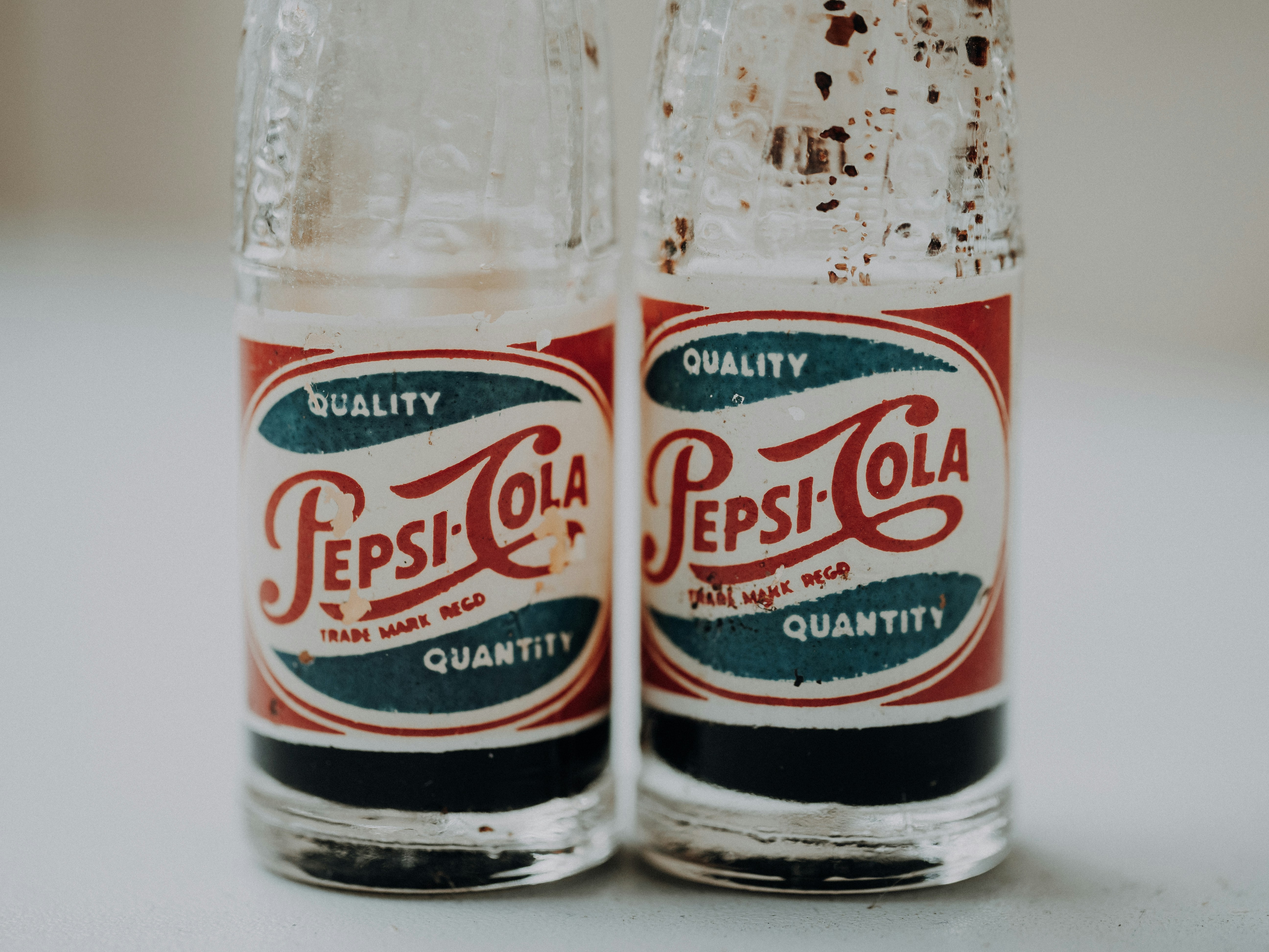 Symmetry in Glass: Dual Pepsi-Cola Bottles with Weathered Labels