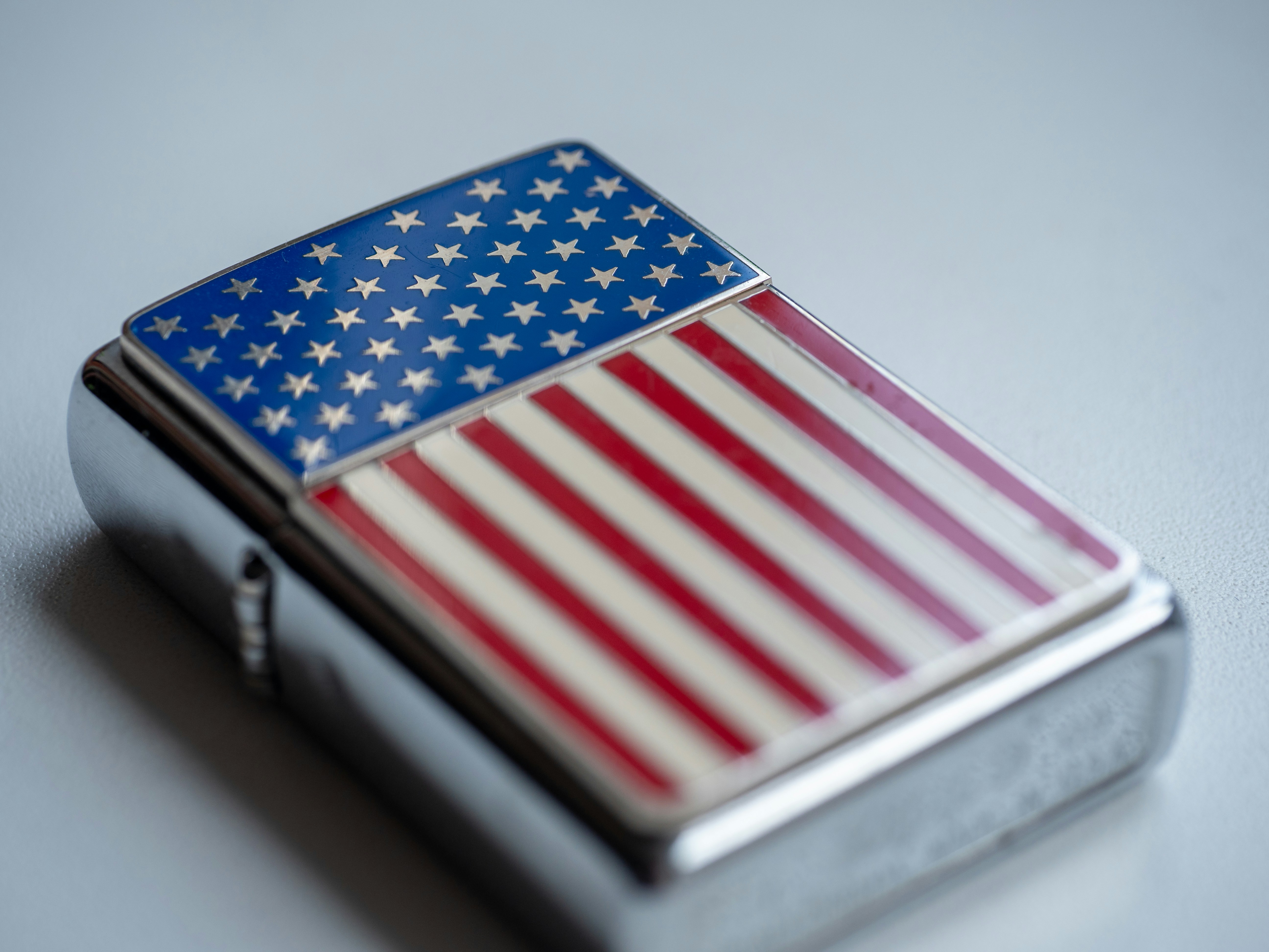An american flag lighter on a white surface. photo – Free Fire Image on ...