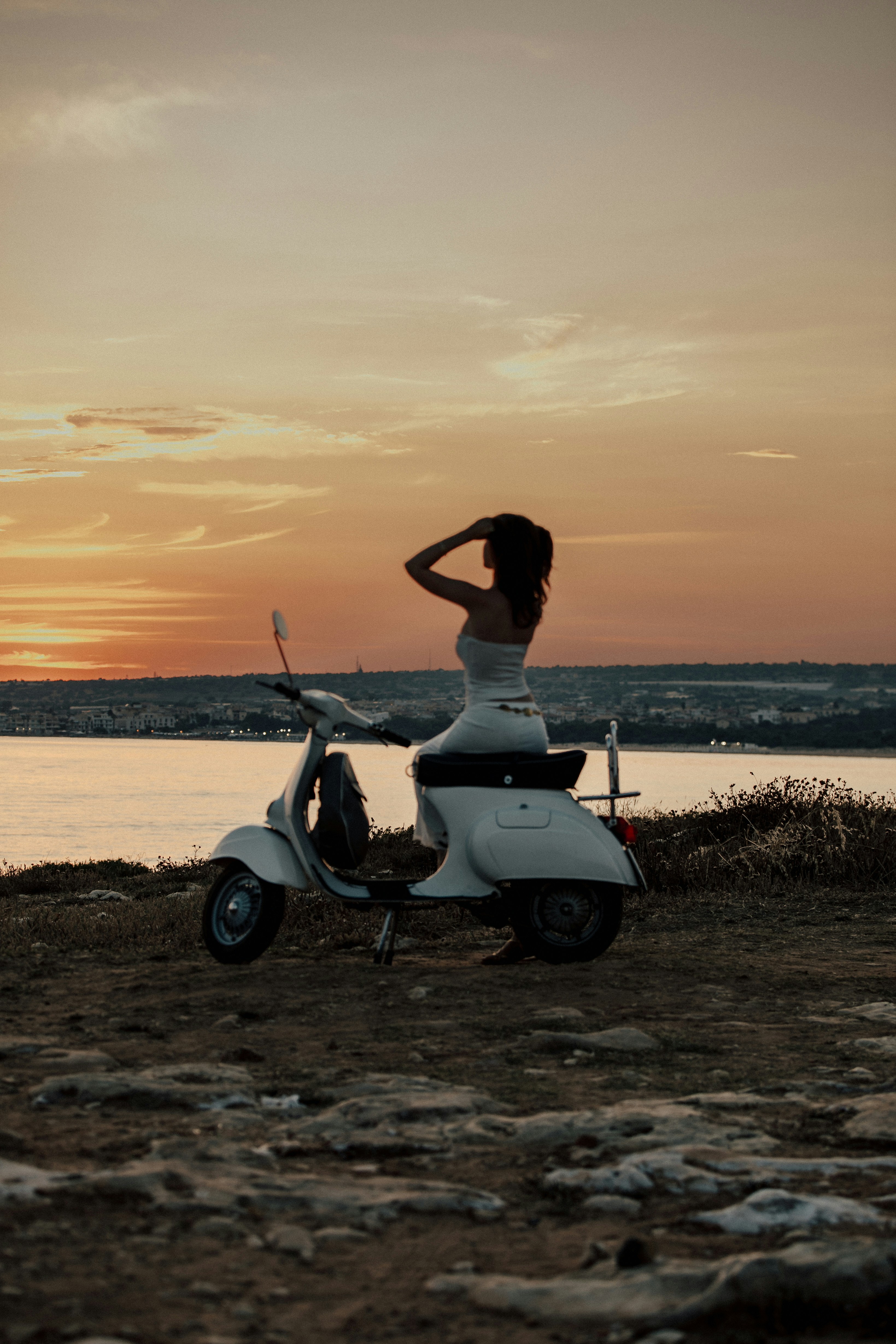 Dusk on the Shore: Woman on a White Vespa