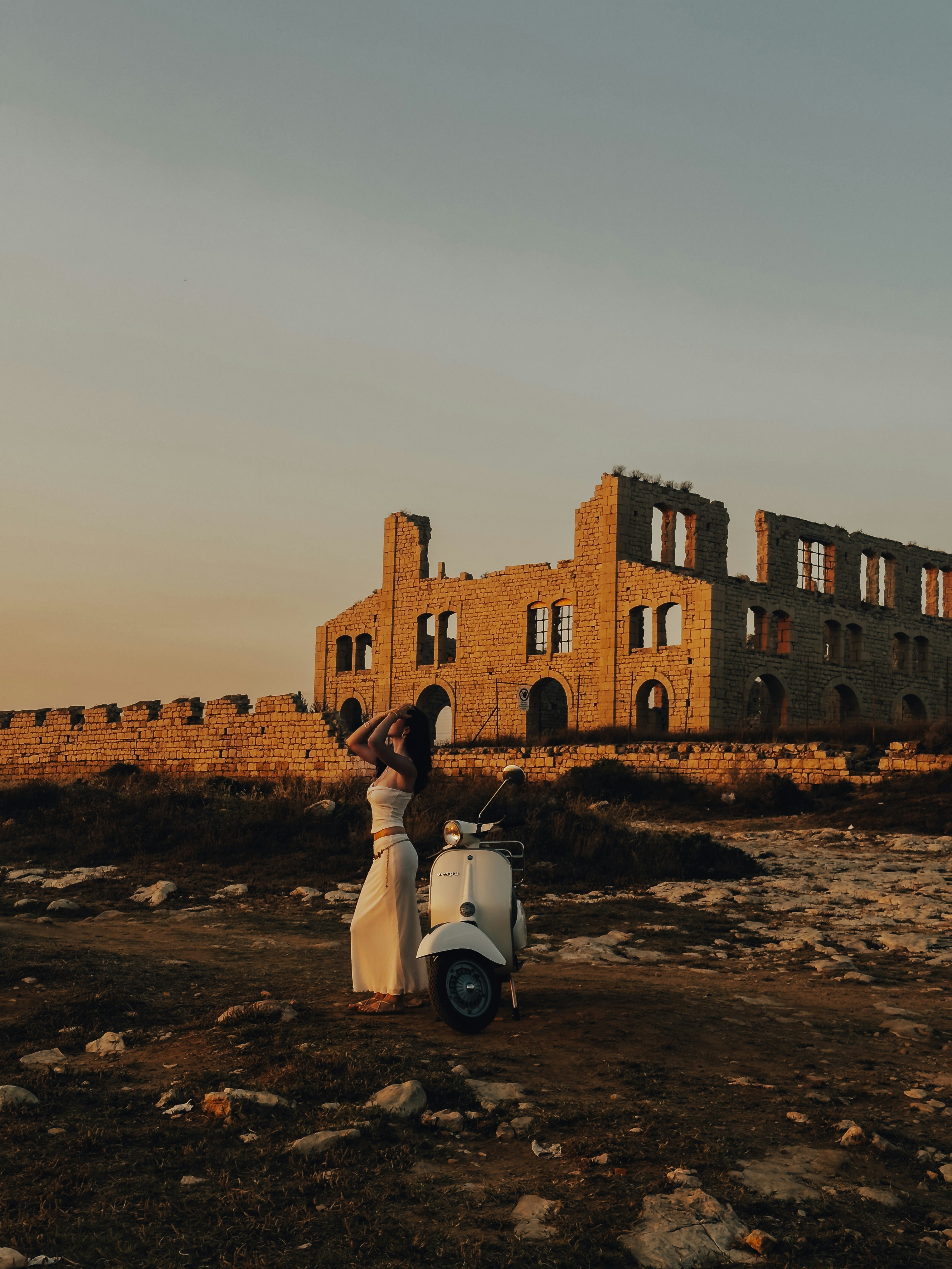 Golden Hour by the Ruins: A Dress-Clad Moment Beside a Vespa