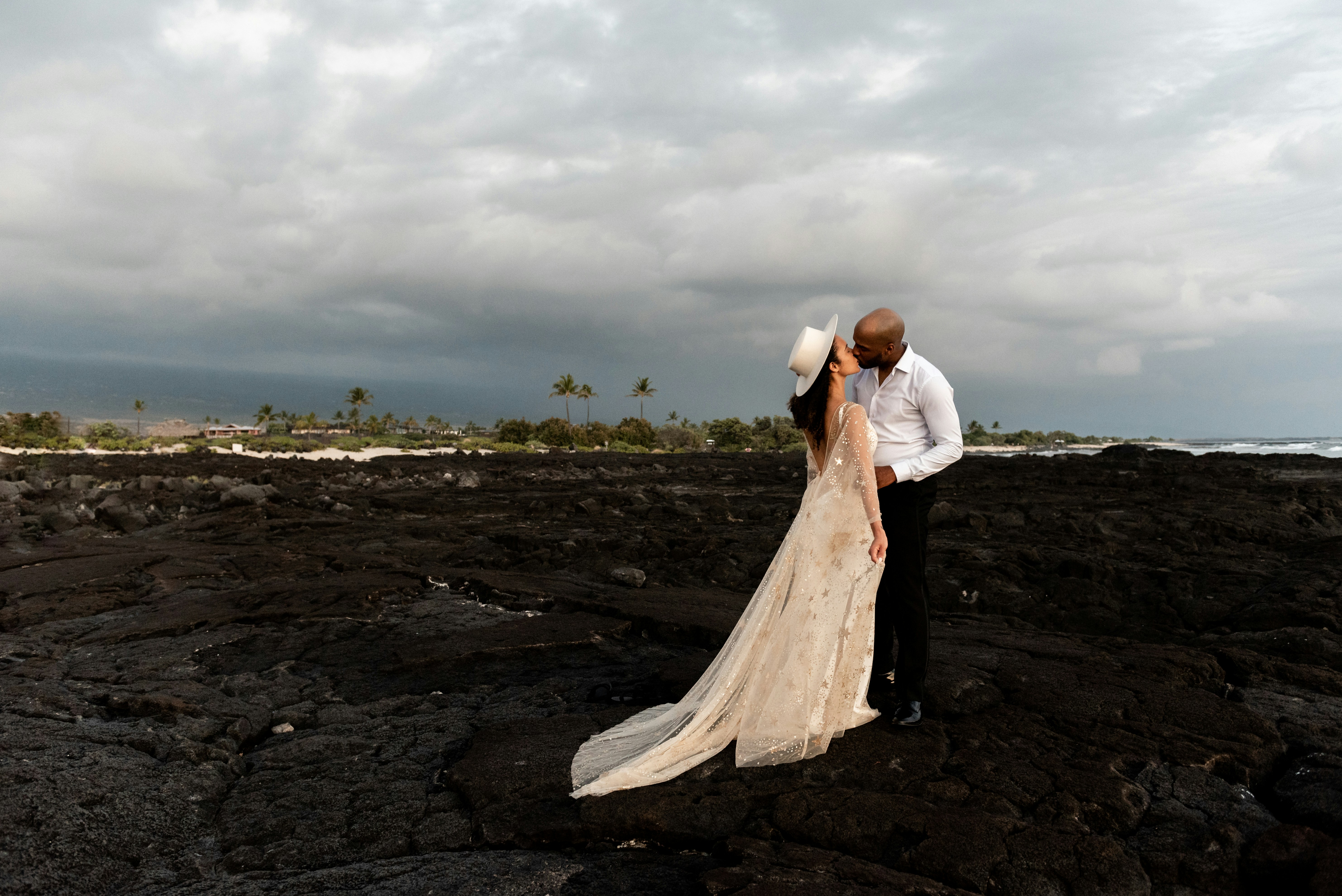 Elopement on the Lava rocks in Hawaii | A newlywed couple shares a kiss outdoors.