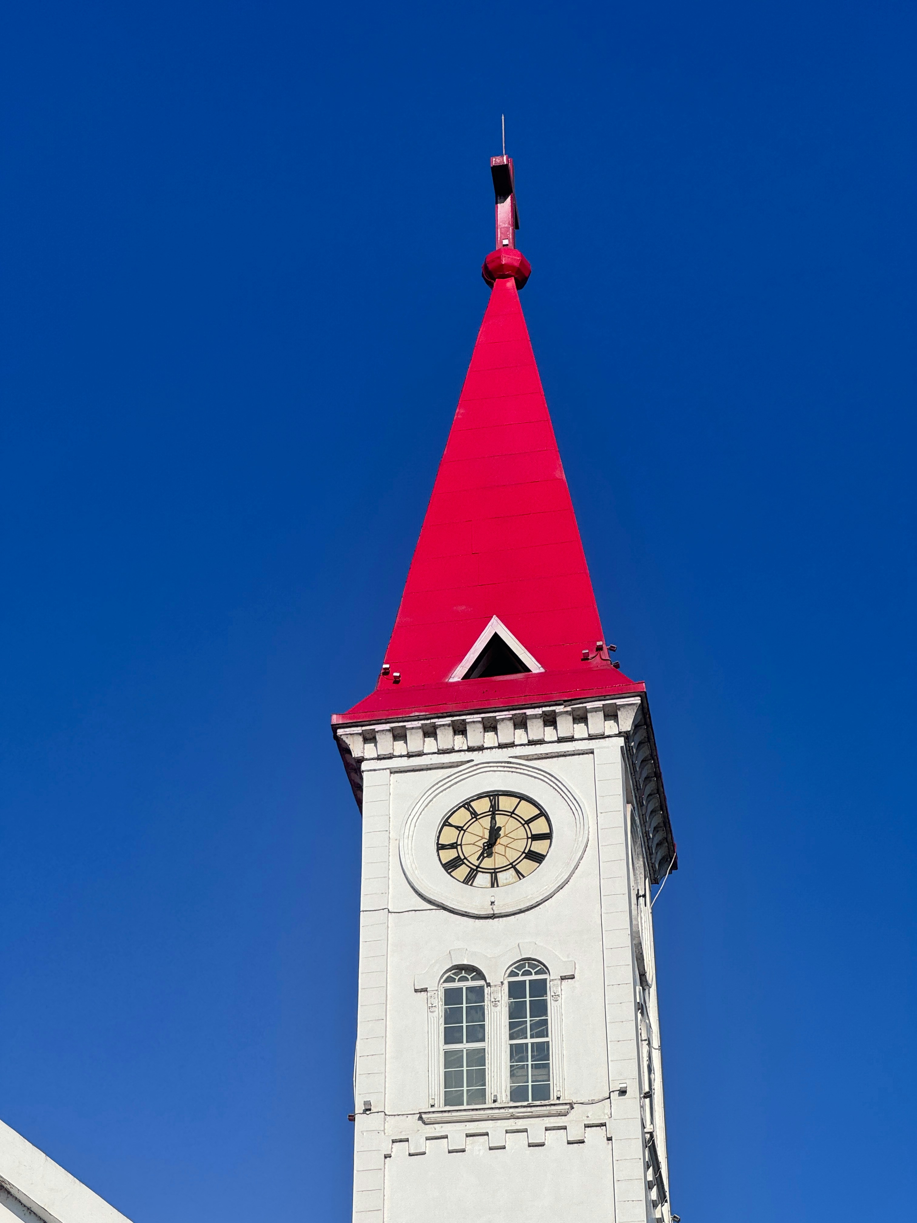 A clock tower features a bright red roof.