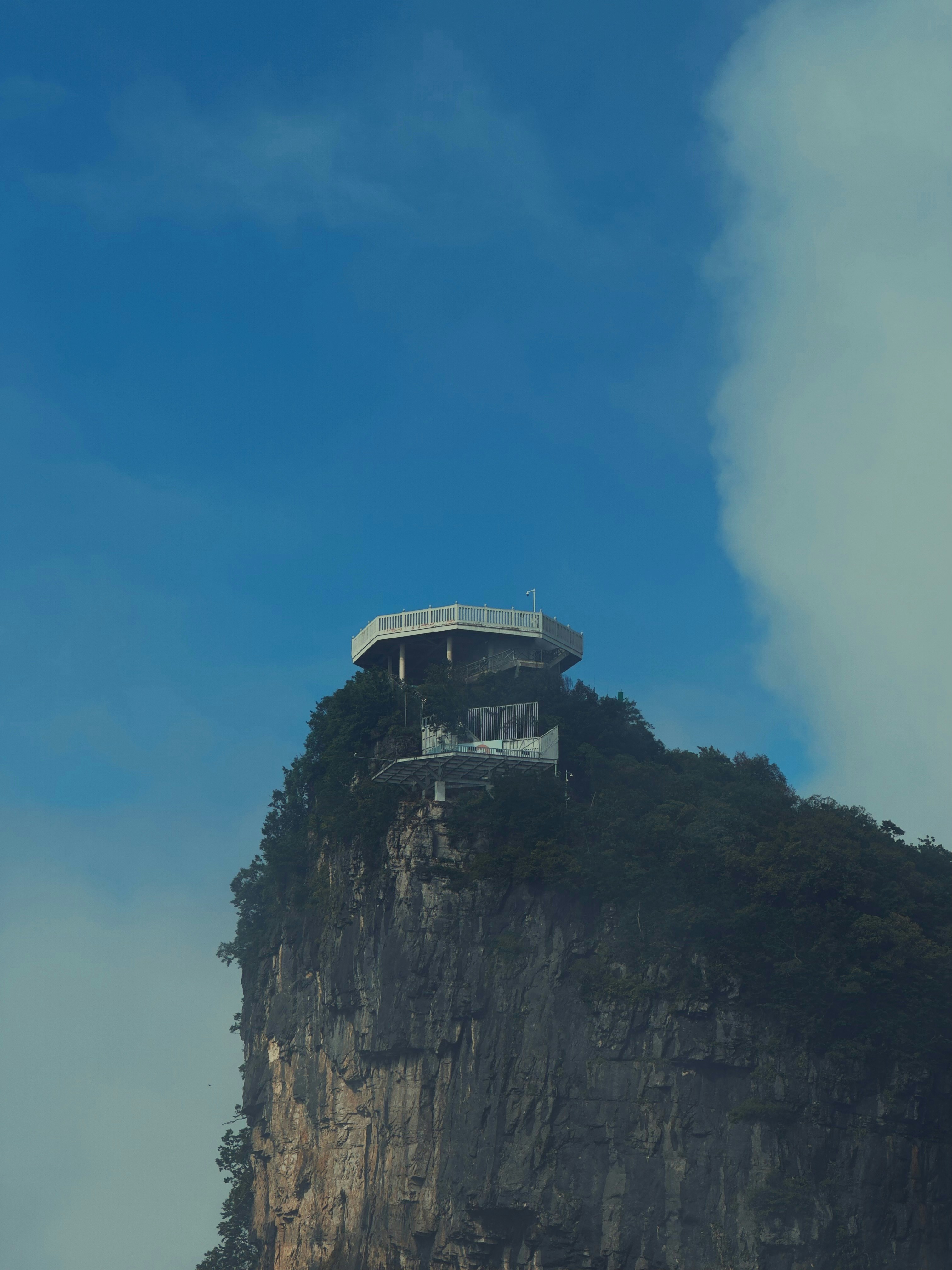 A building sits atop a rocky mountain.