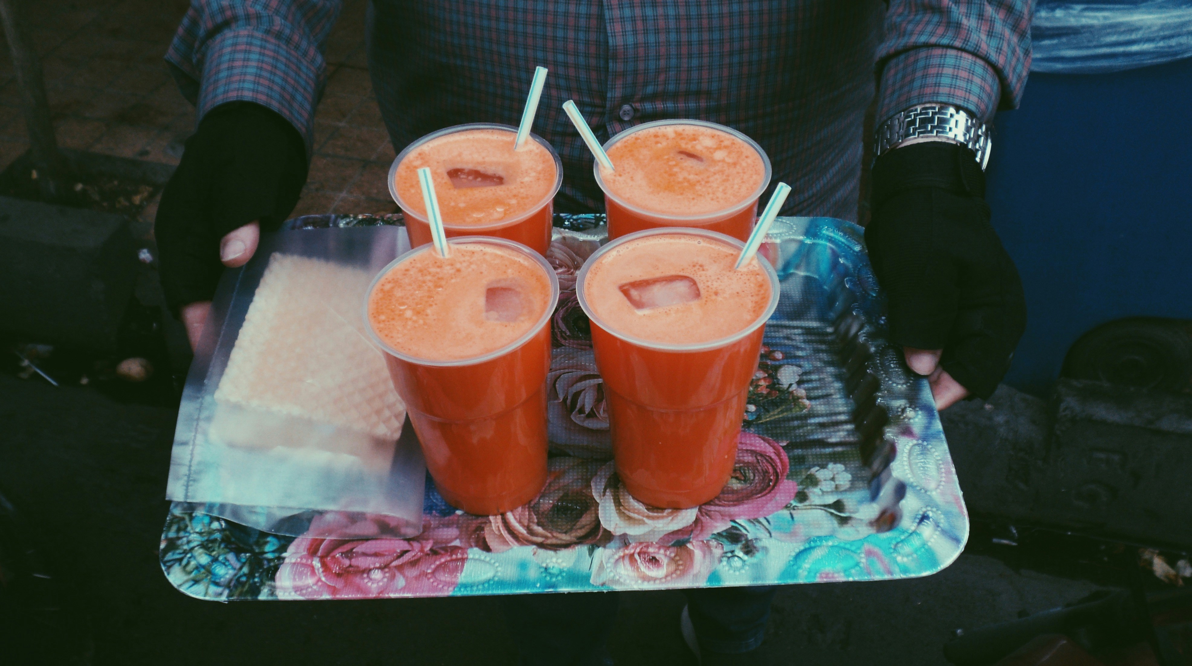 A small break in a busy day. | A person is carrying a tray of orange juice.