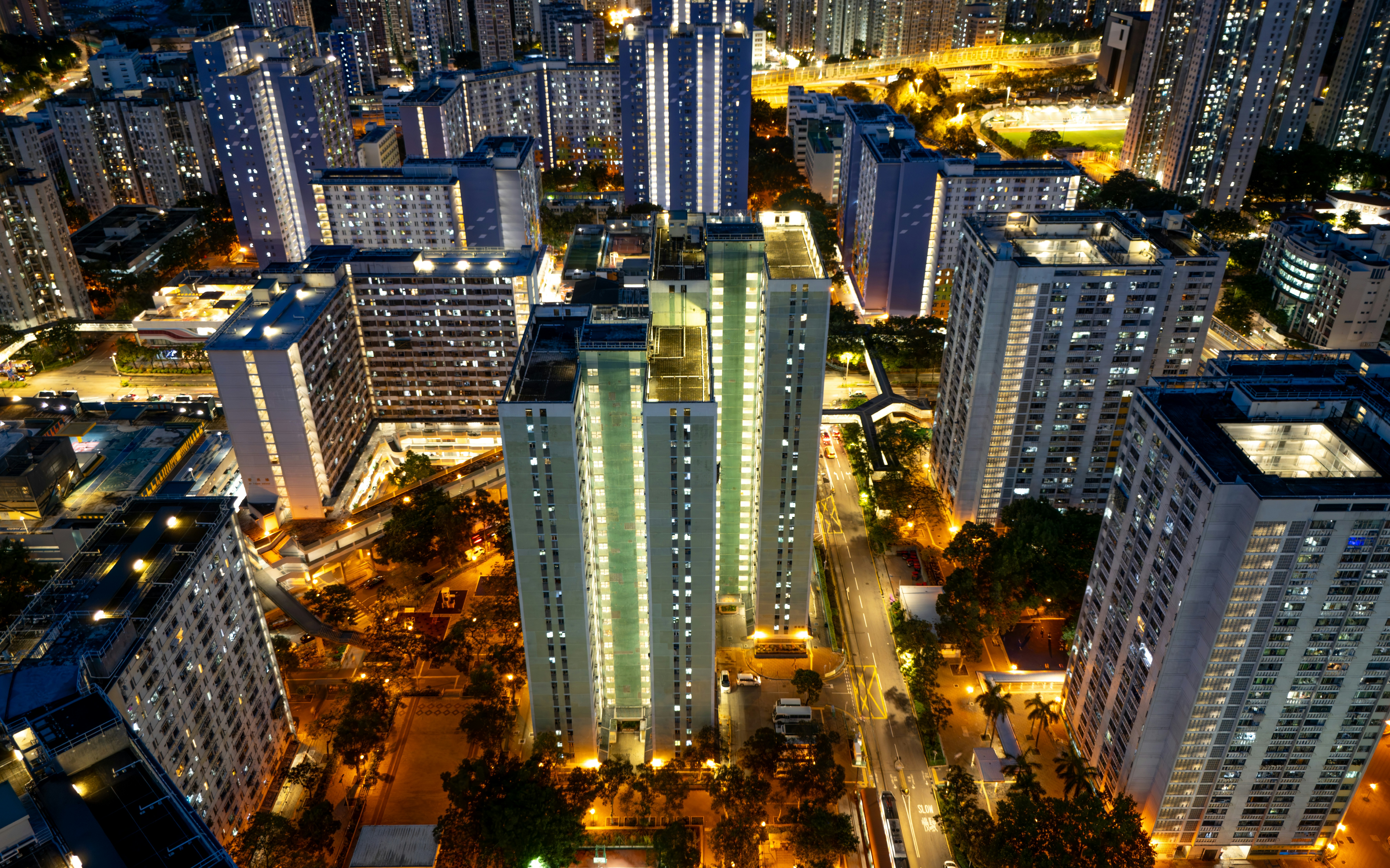 Nighttime cityscape with illuminated skyscrapers and buildings.