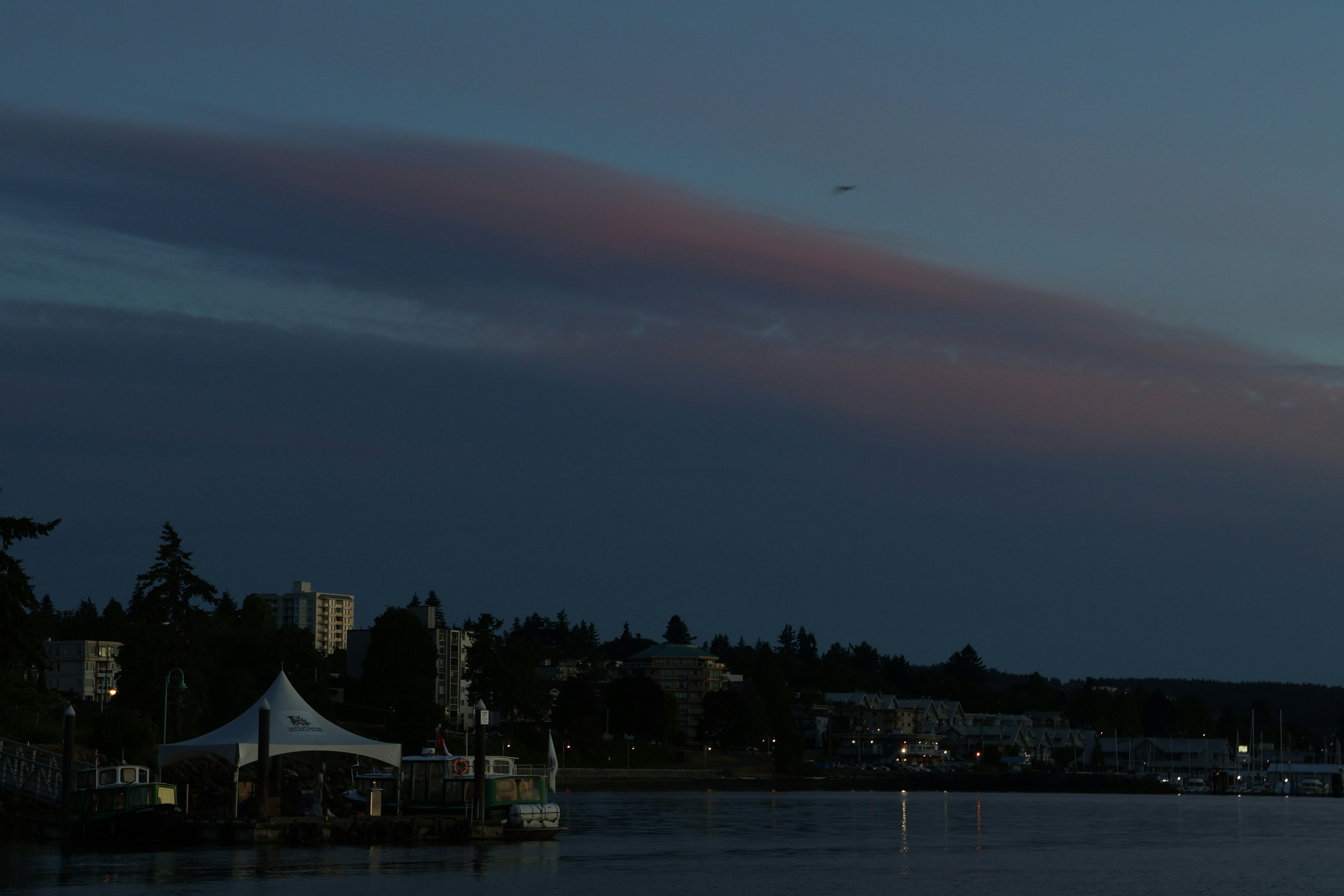 Evening sky with a boat and cityscape.