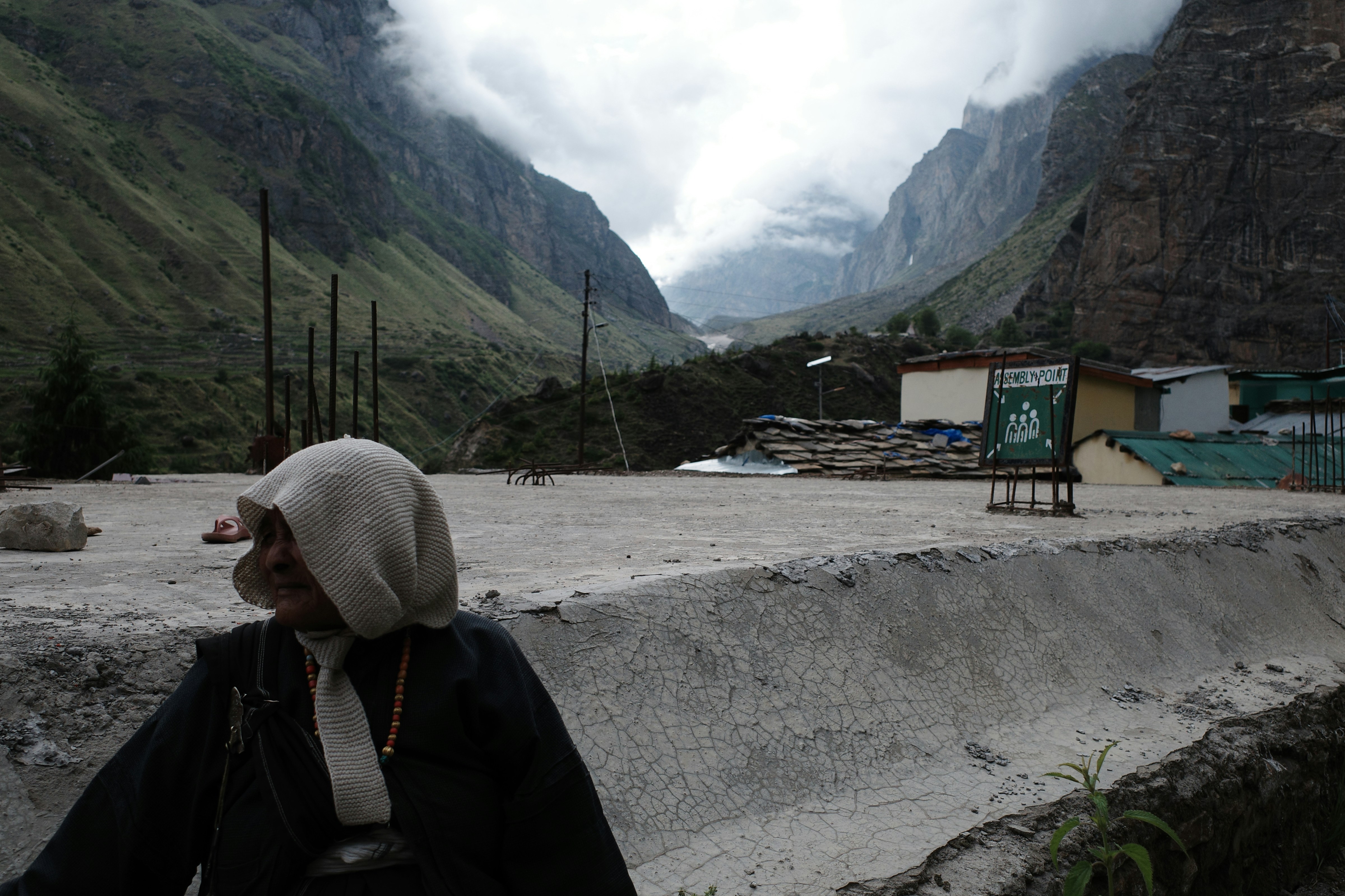 Hooded Traveler by a Cracked Spillway Beneath Towering Canyon Walls