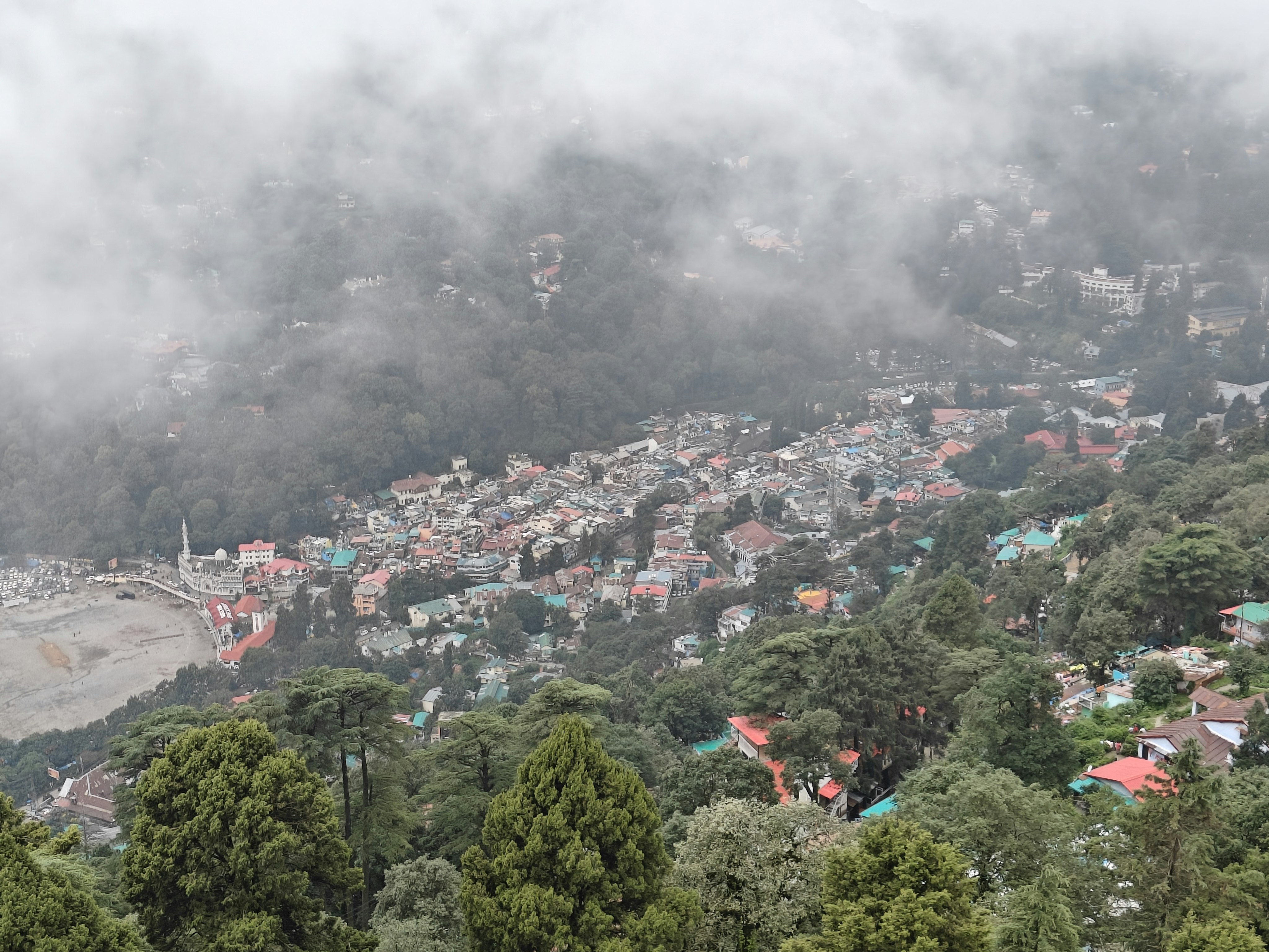 Nainital city from top | A misty town nestled among lush trees.