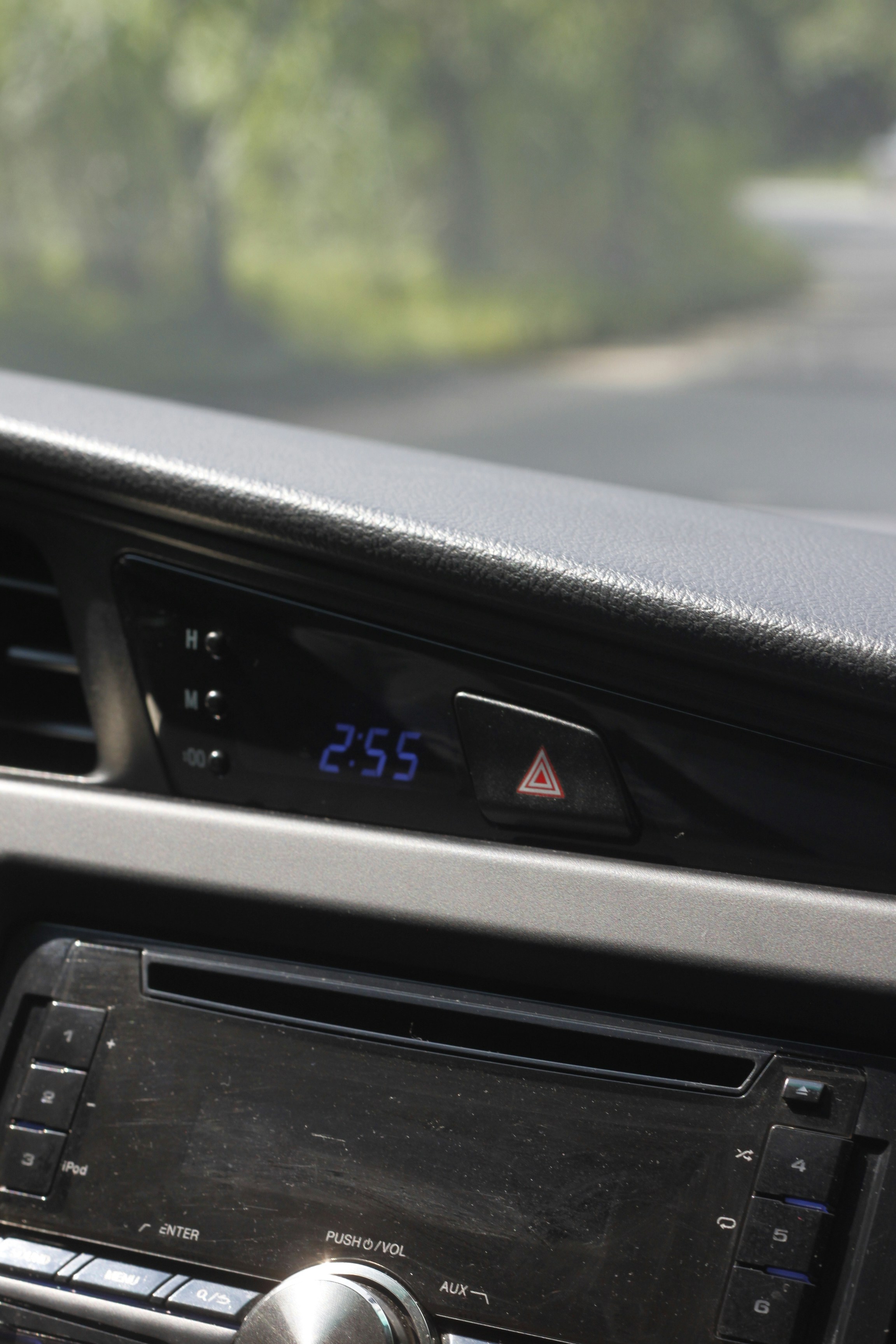 Dashboard Clock and Hazard Button: Focused View Through the Car Cabin