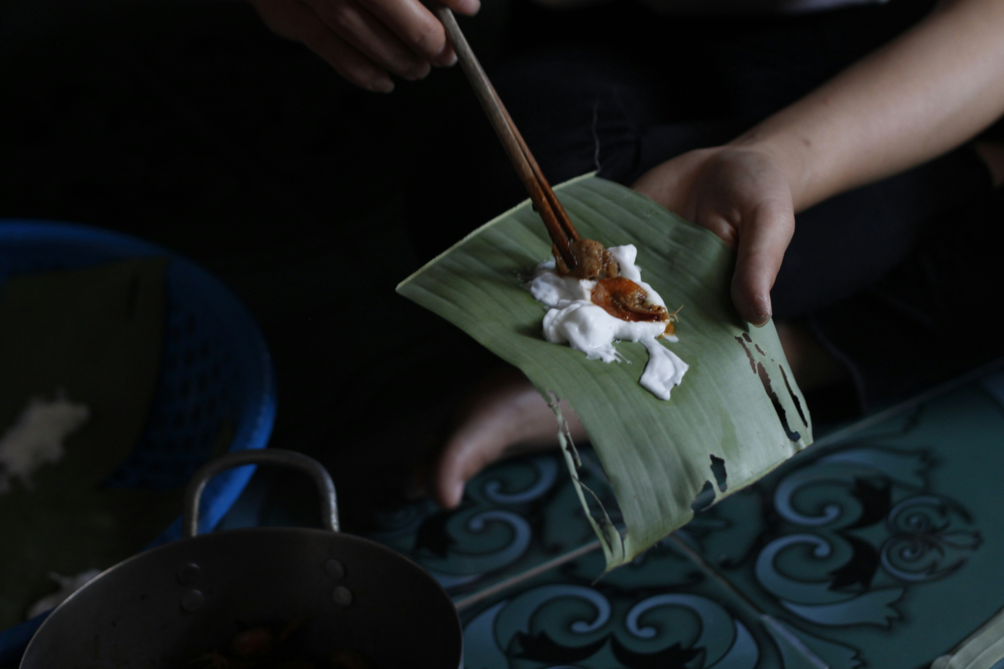 Someone is preparing food on a banana leaf.