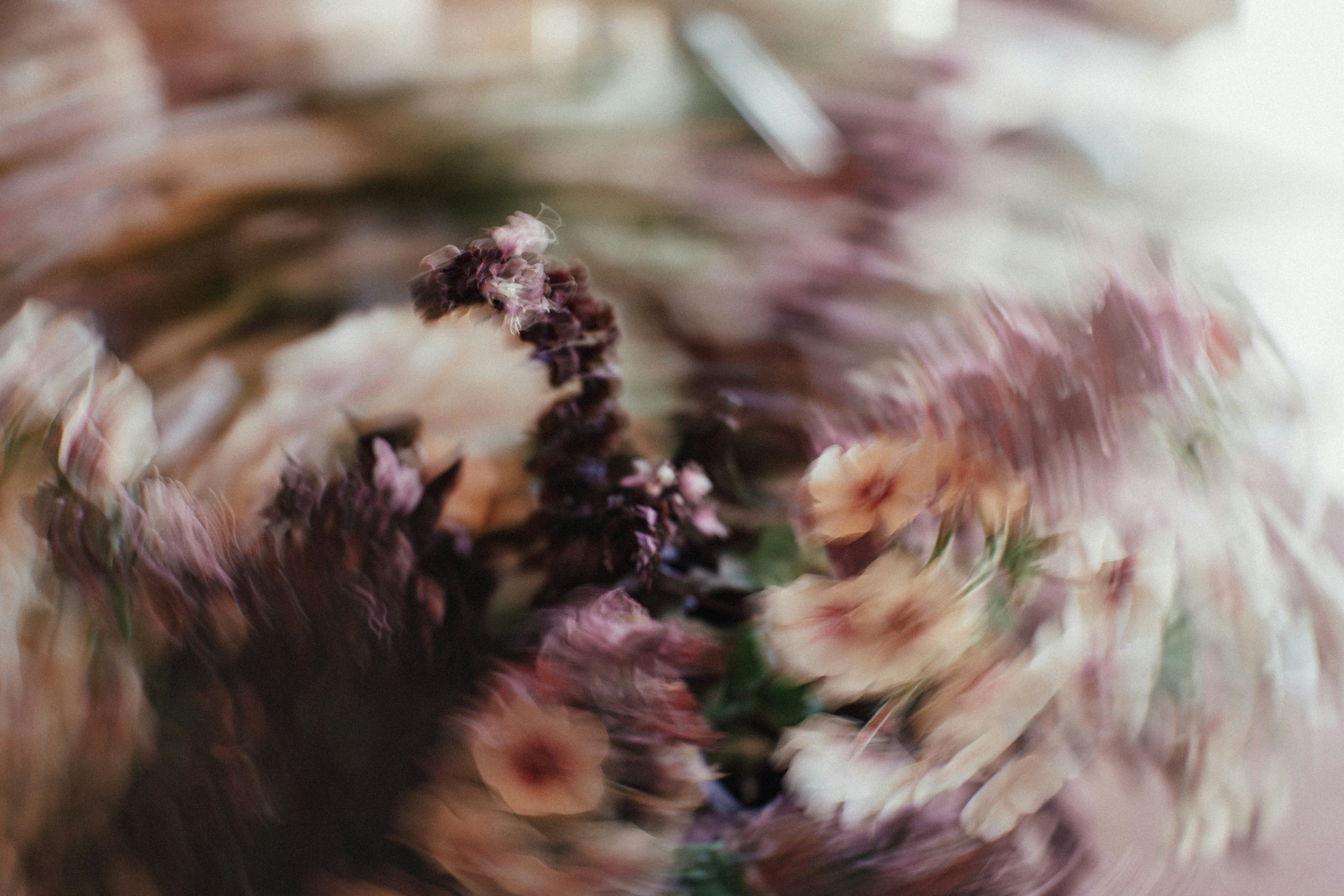 A vibrant bouquet of flowers captured in dynamic motion, showcasing a blur of colors and forms. The swirling arrangement evokes a sense of movement and life.
