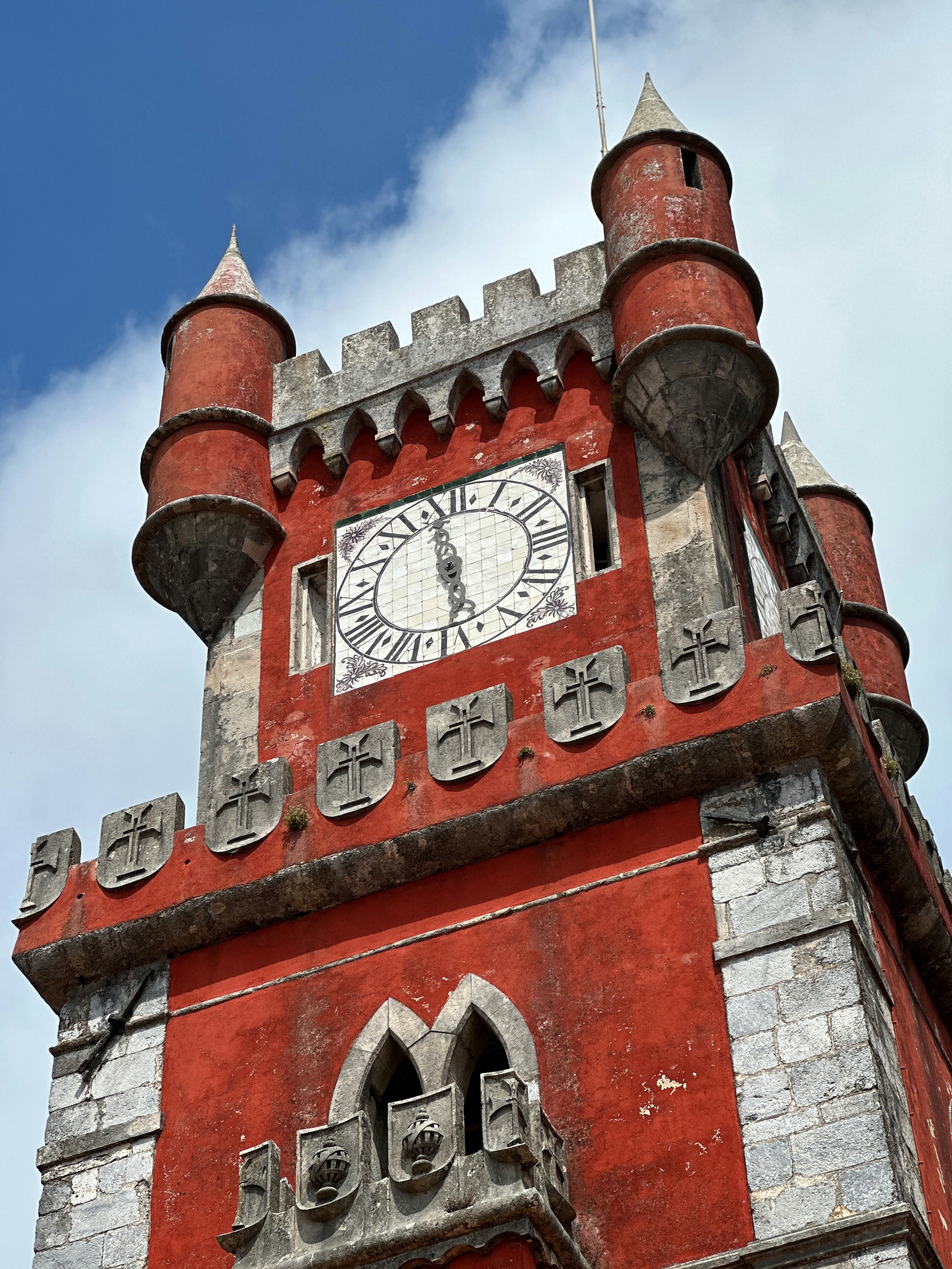 A red and white castle tower with a clock.