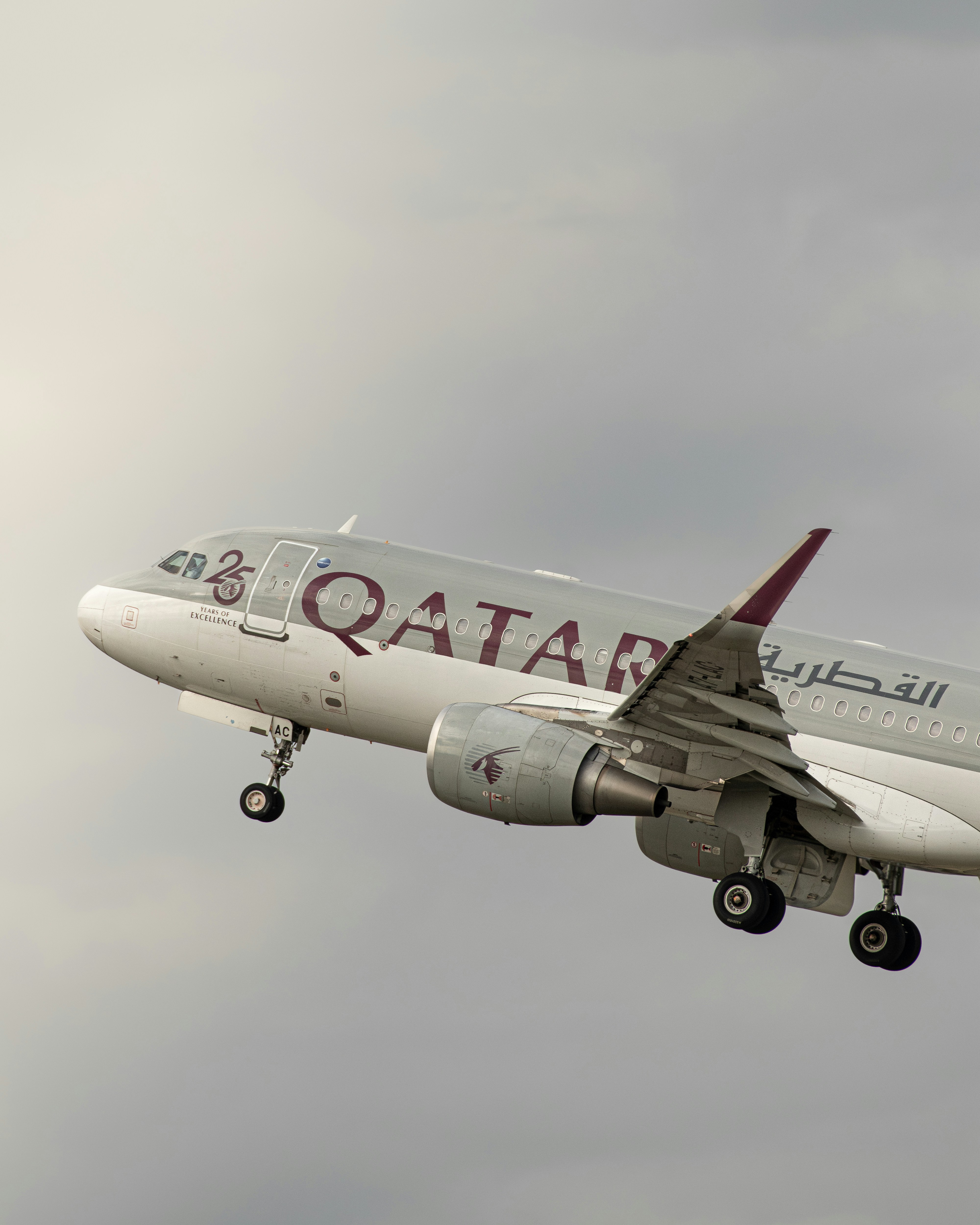 A qatar airways plane takes off into the sky.