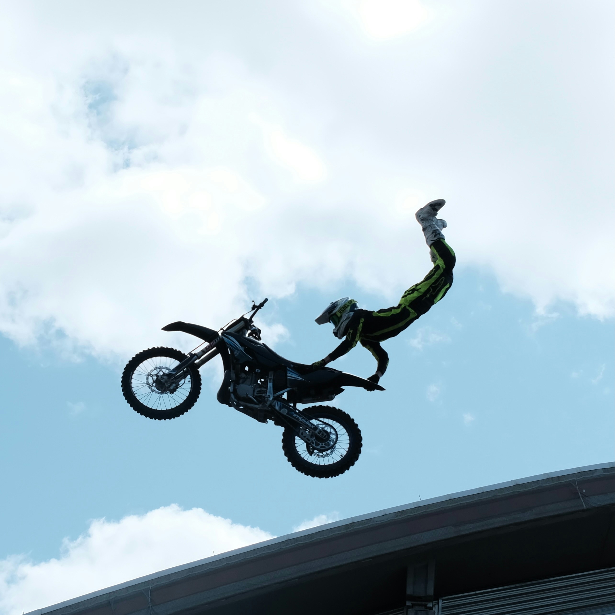 Neon Rider Soars: Aerial Motocross Leap Over a Concrete Ramp