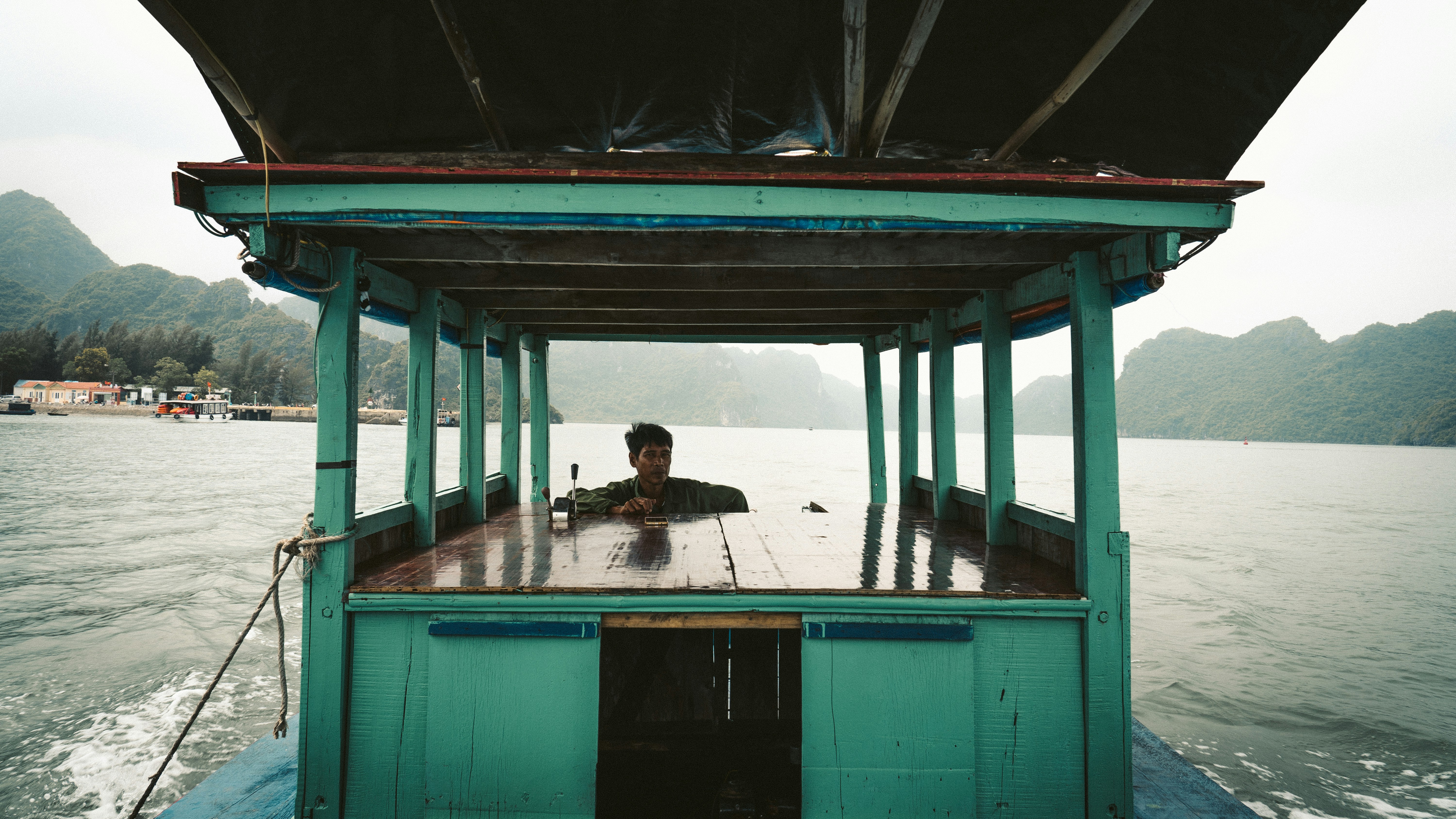 Turquoise Deck, Quiet Waters: A Lone Figure on a Lake Boat