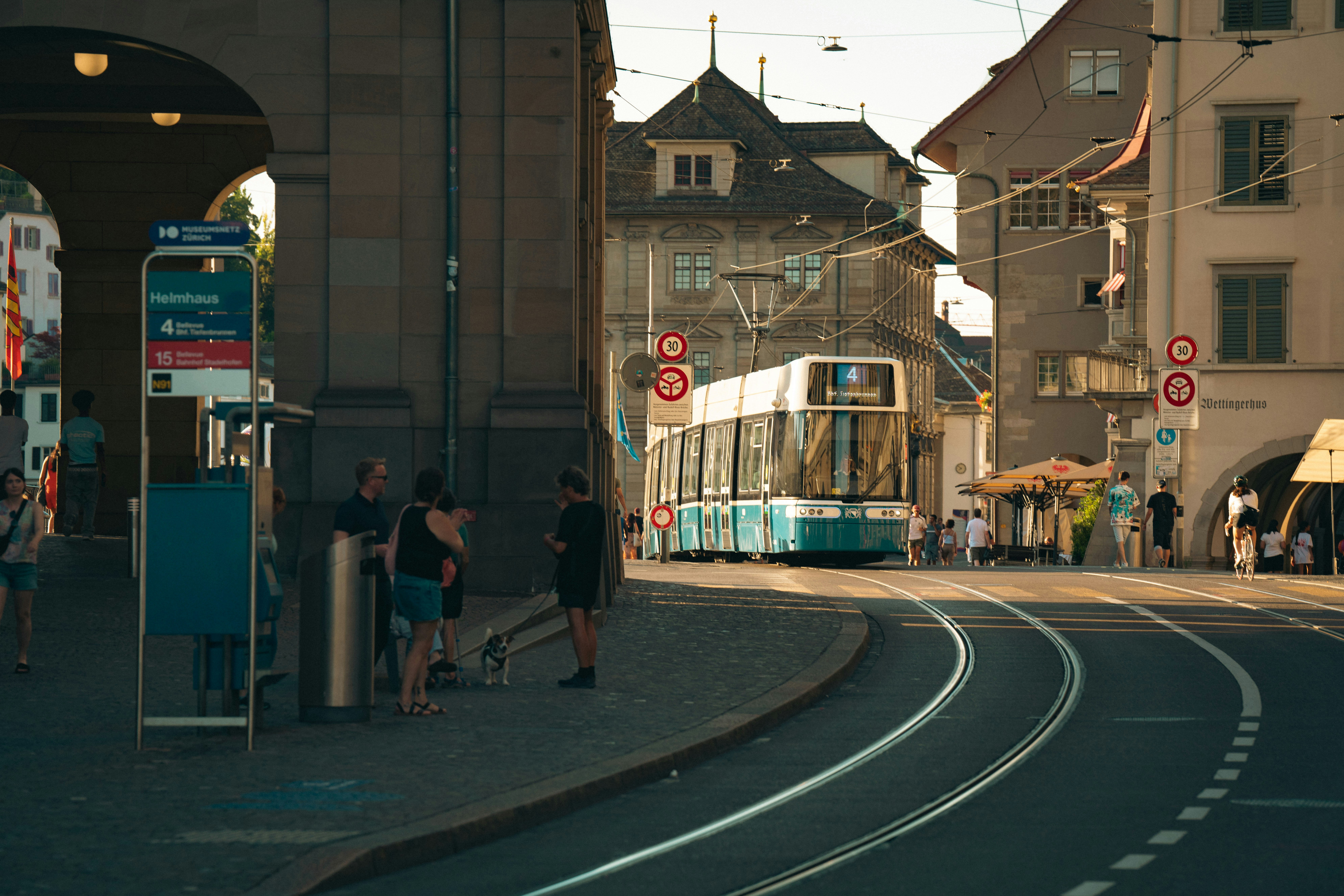 A tram pulls up to a busy street.