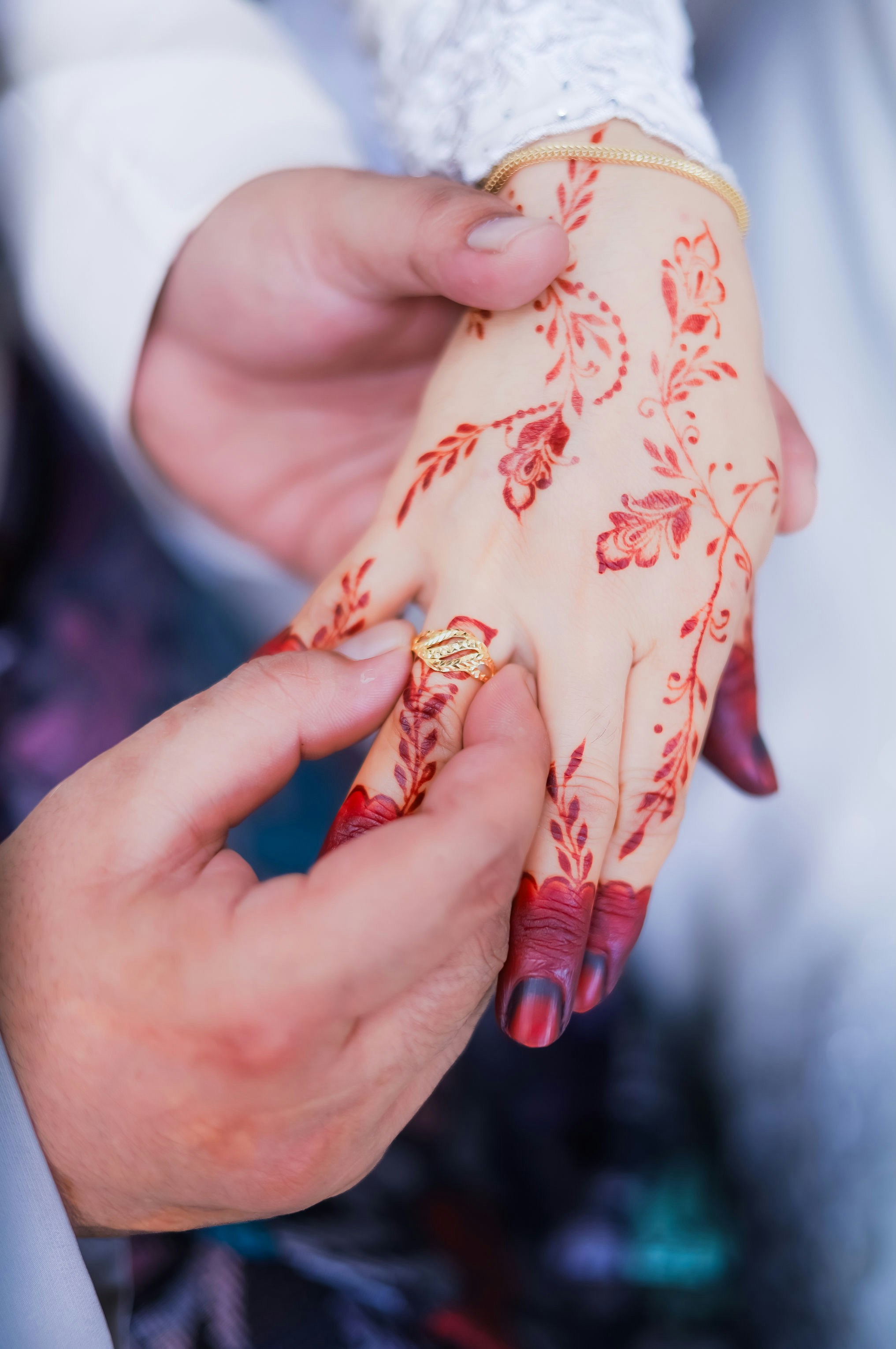 A wedding ring is being placed on a finger.