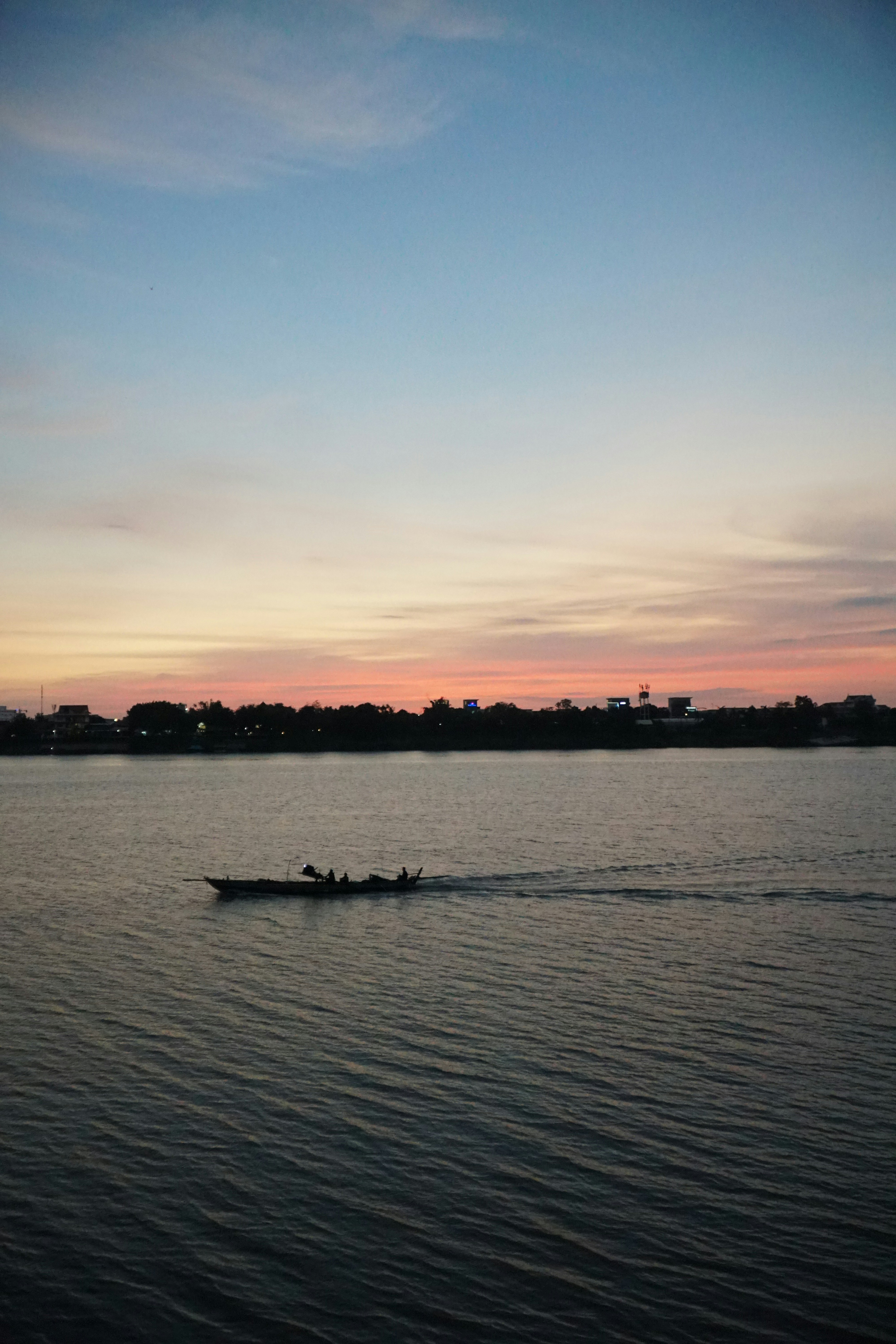 Sunset casts colors over a boat on the water.