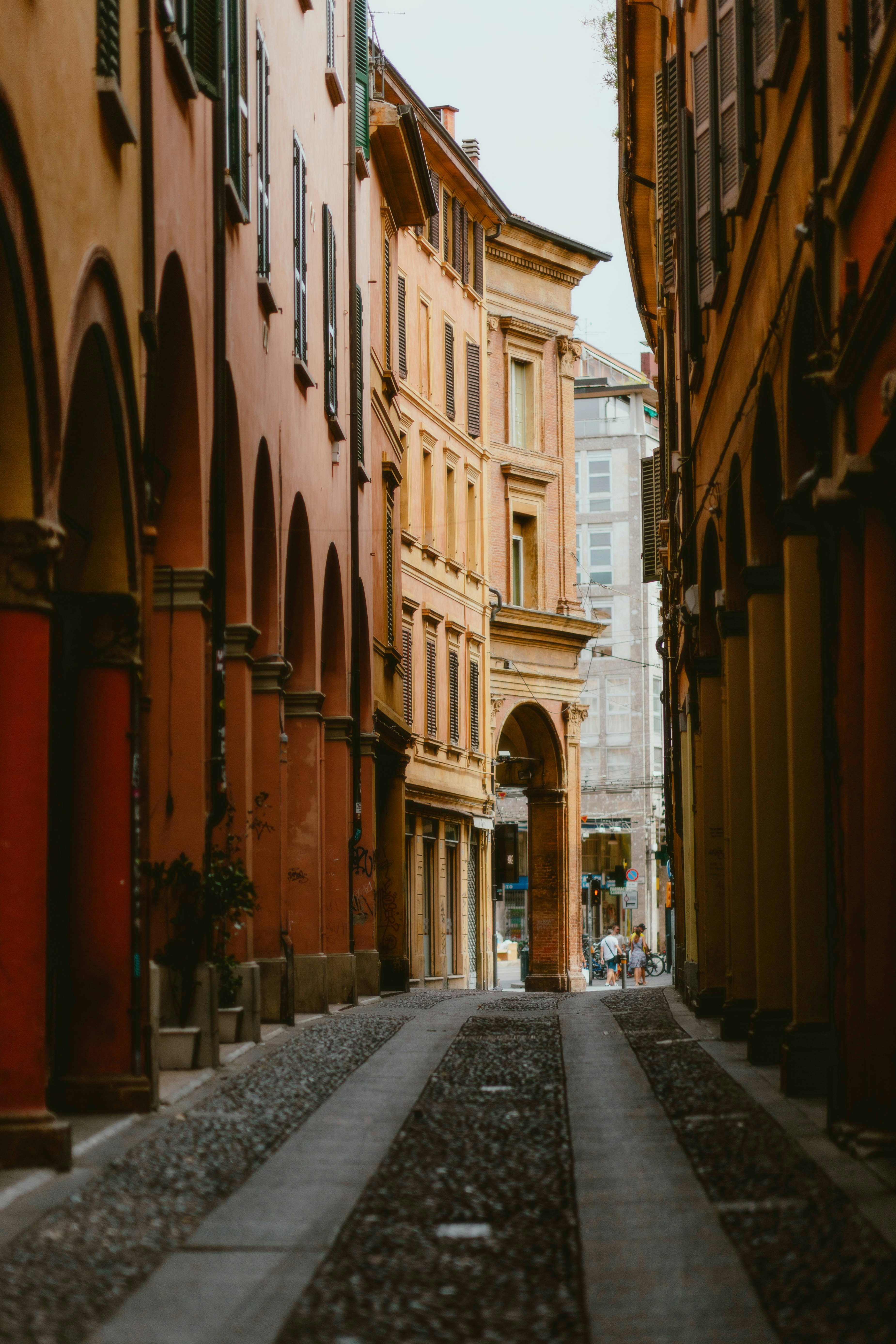 Cobblestone street flanked by colorful buildings.