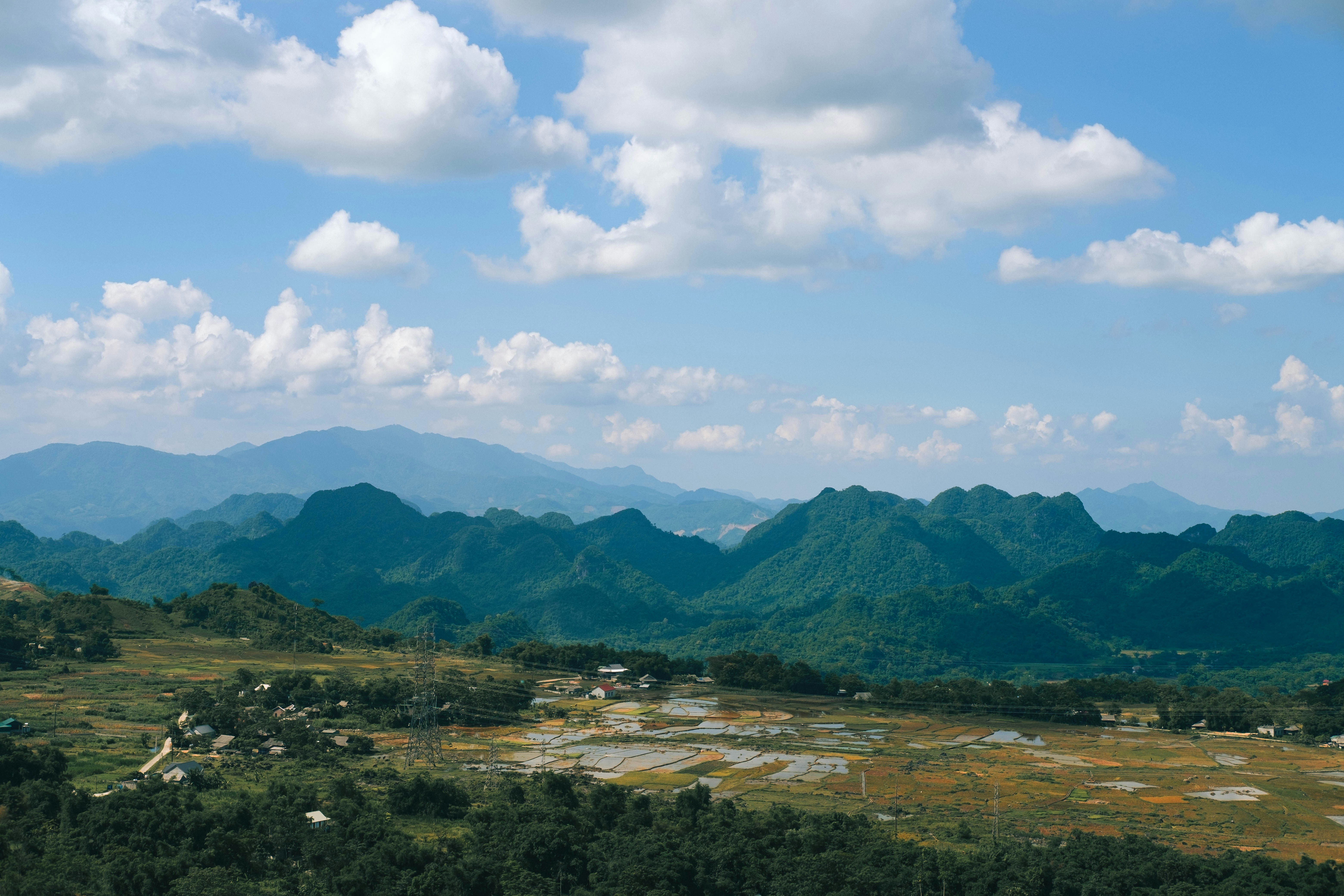 Hills and mountains under a bright, cloudy sky.